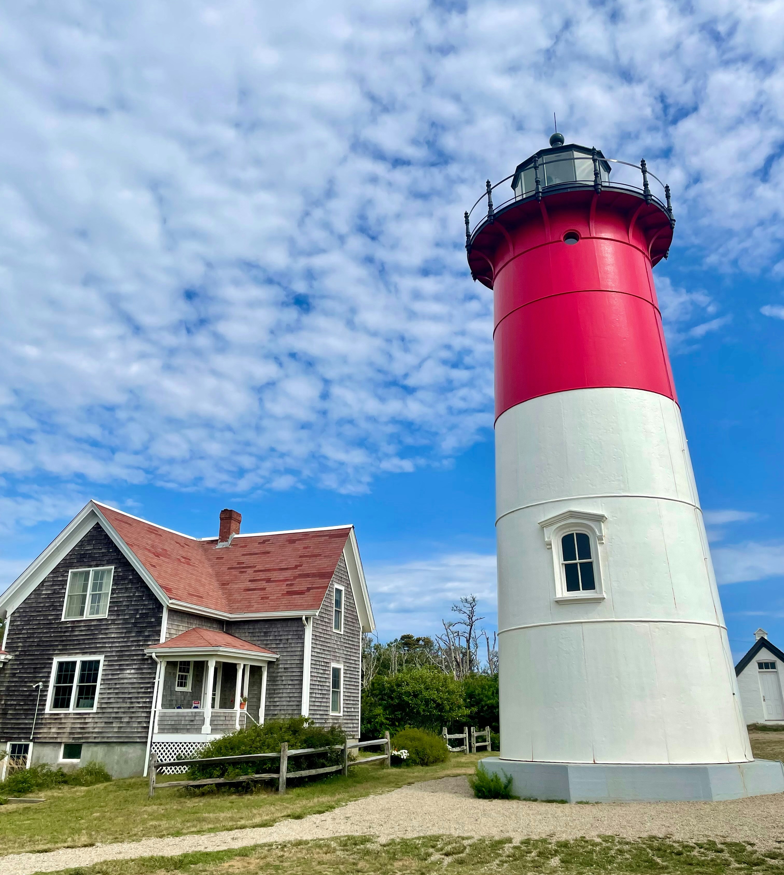 A red and white lighthouse sitting next to a house photo – Free Human ...