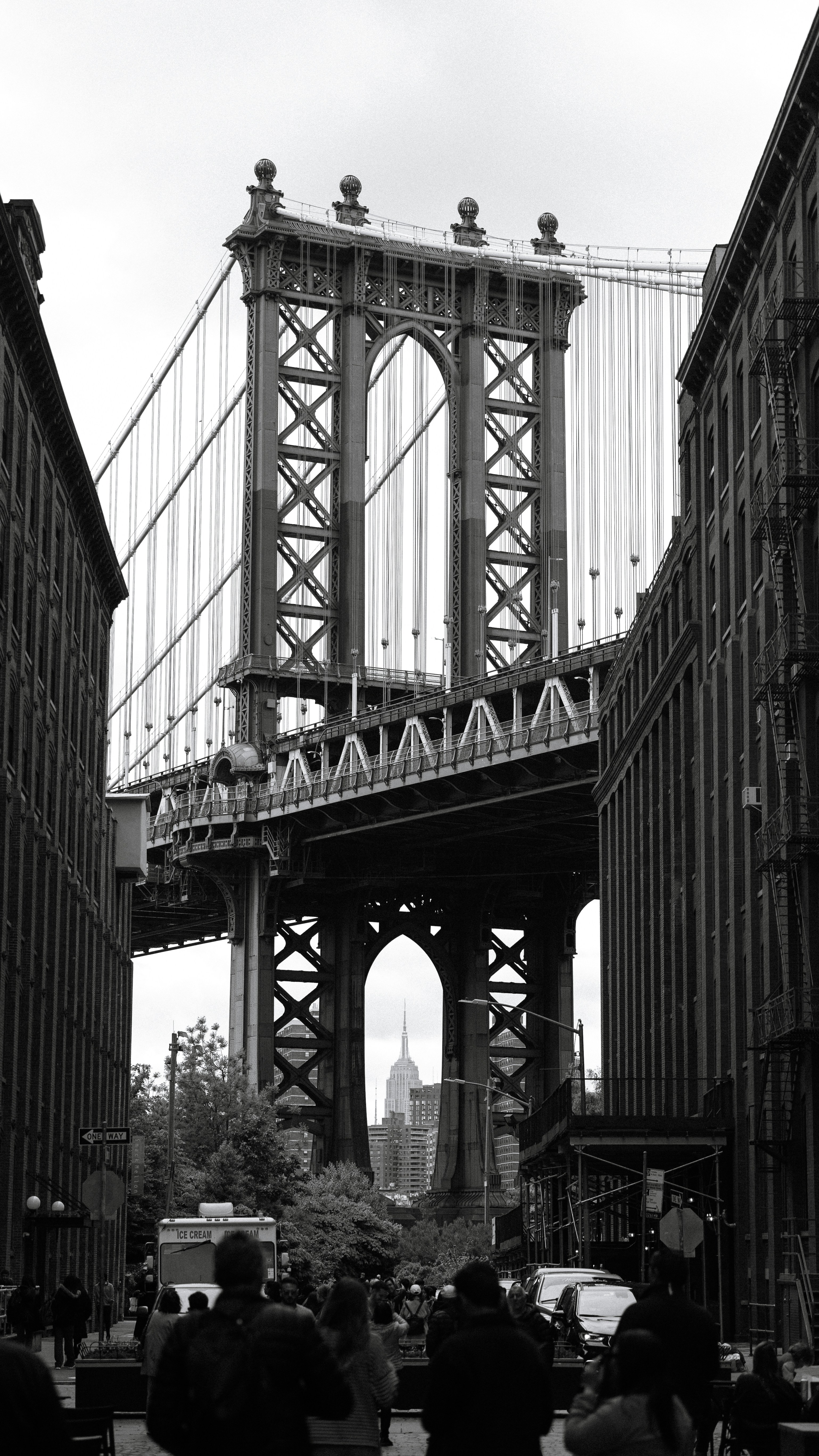 A black and white photo of people walking under a bridge photo – Free ...
