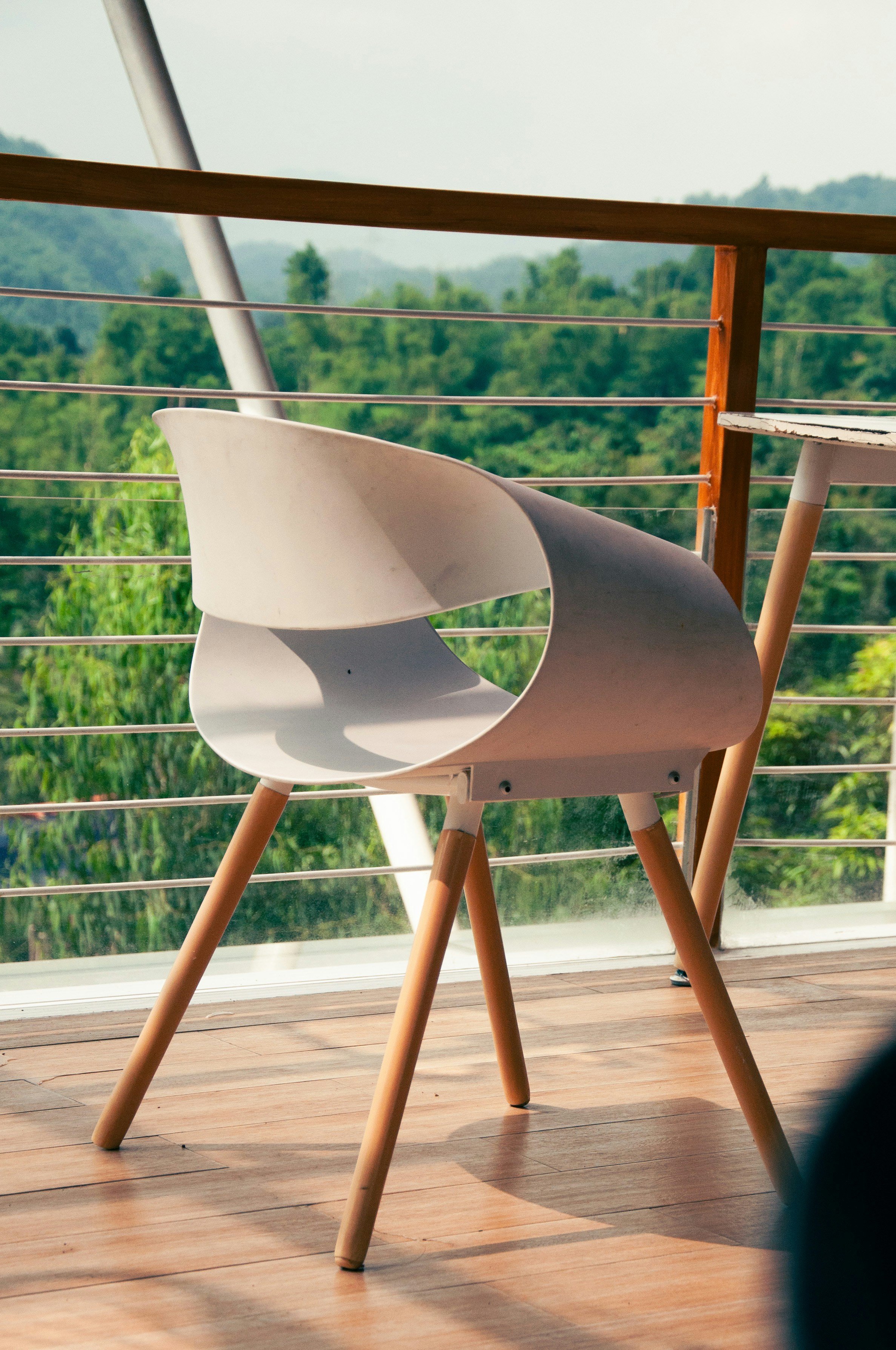 Sunlit White Chair Framing a Balcony Overlook of Green Hills