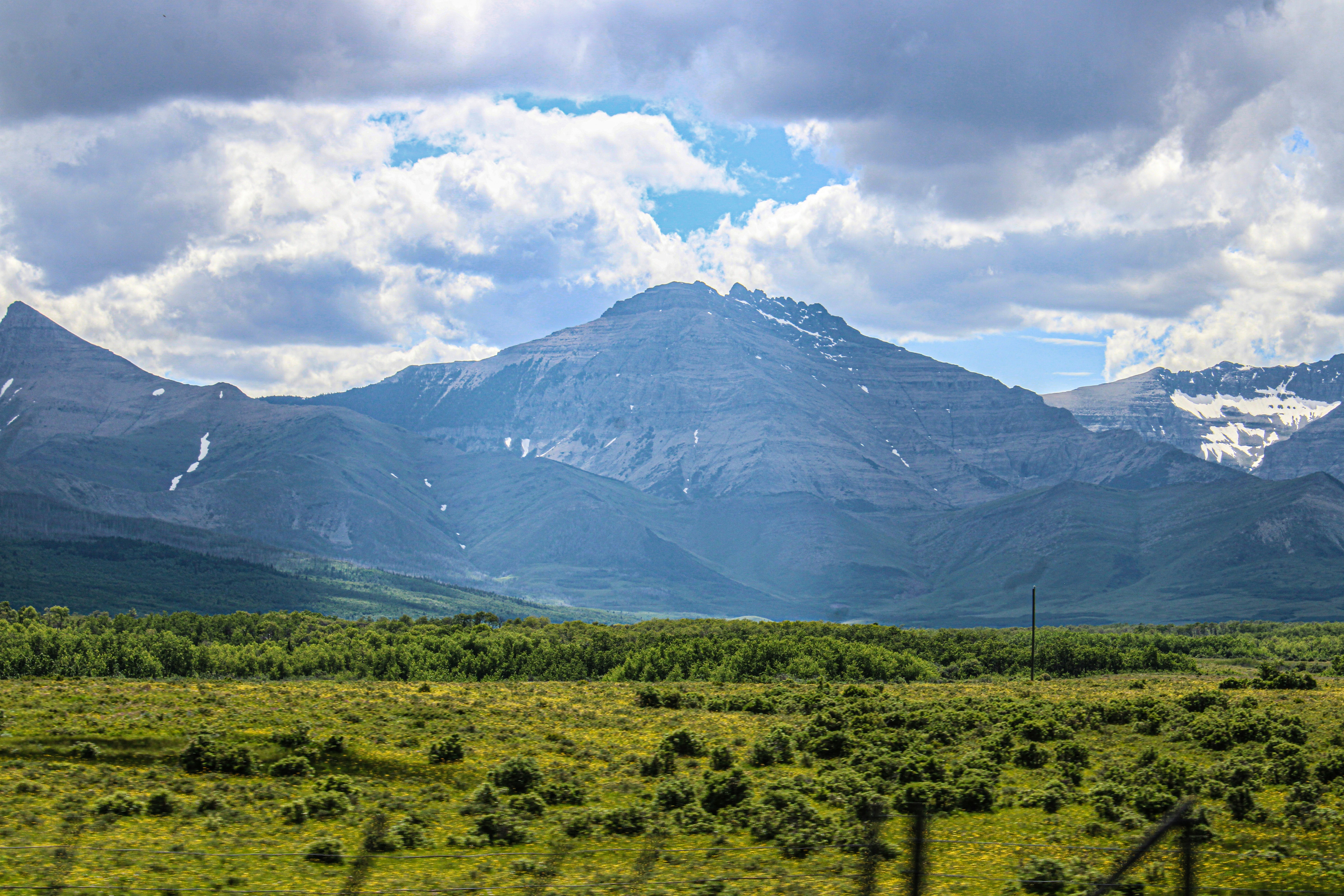 A grassy field with mountains in the background photo – Free Land Image ...