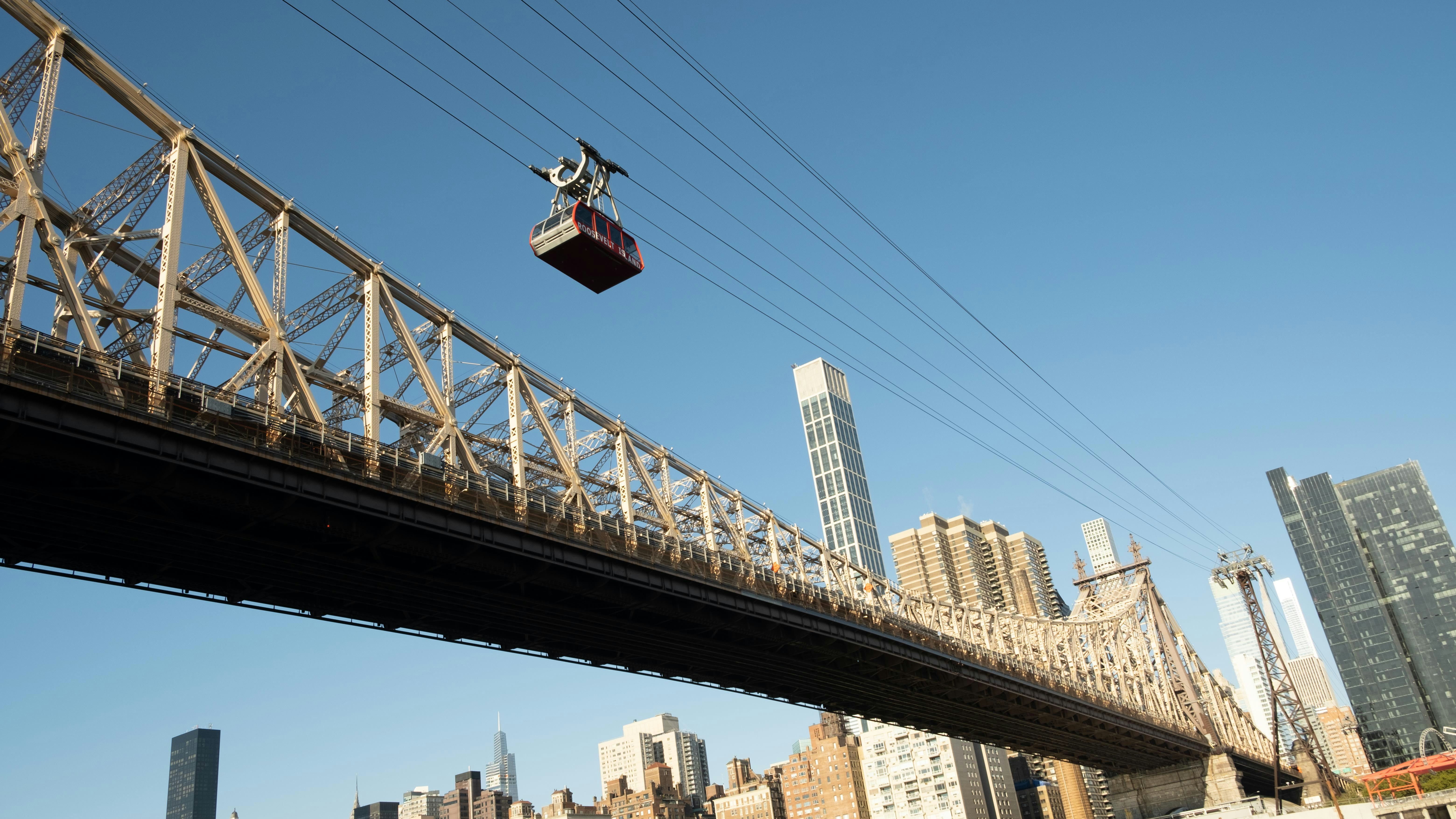 Over the Steel Span: A Cable Car Crossing the City Skyline