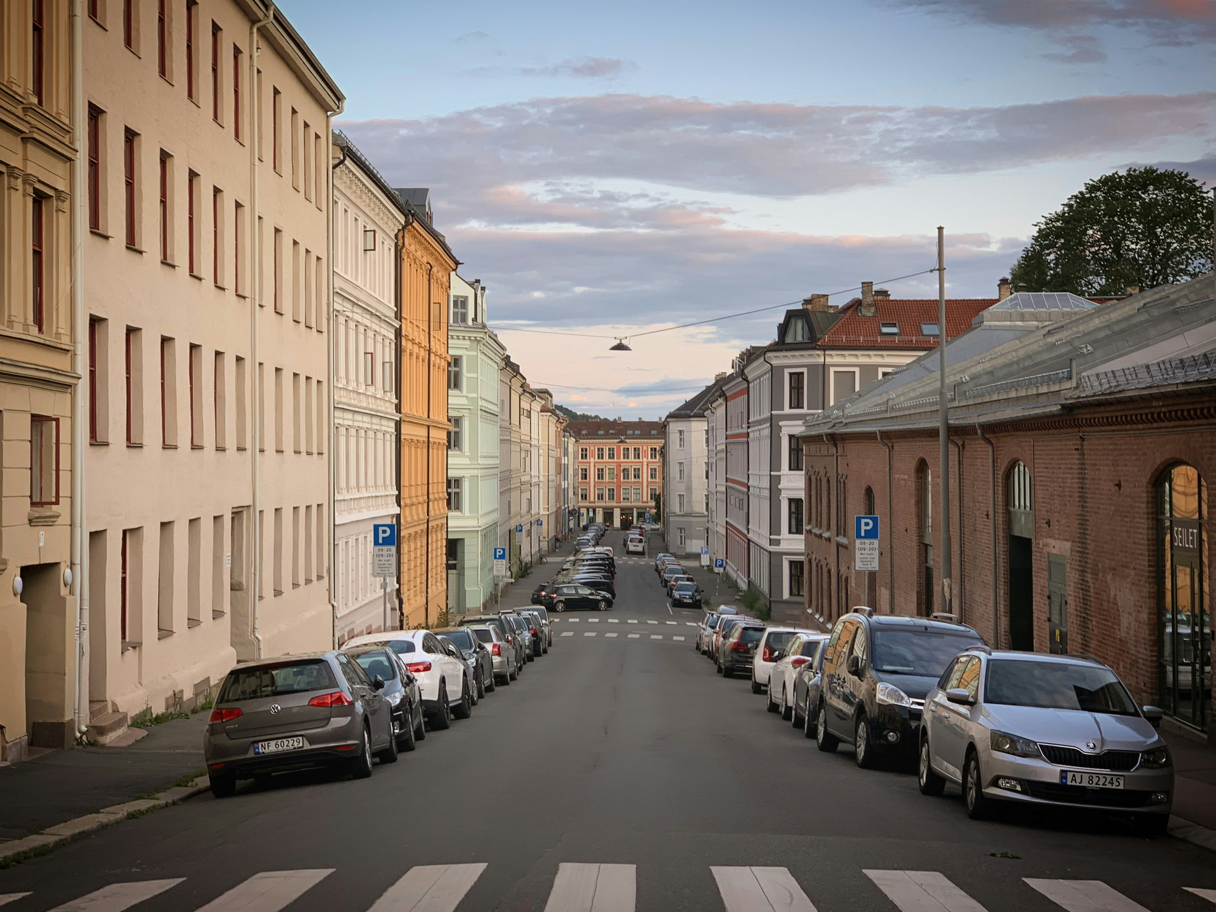 A street with the old houses and the parked cars in the Grünerløkka district of Oslo, Norway, August 2019