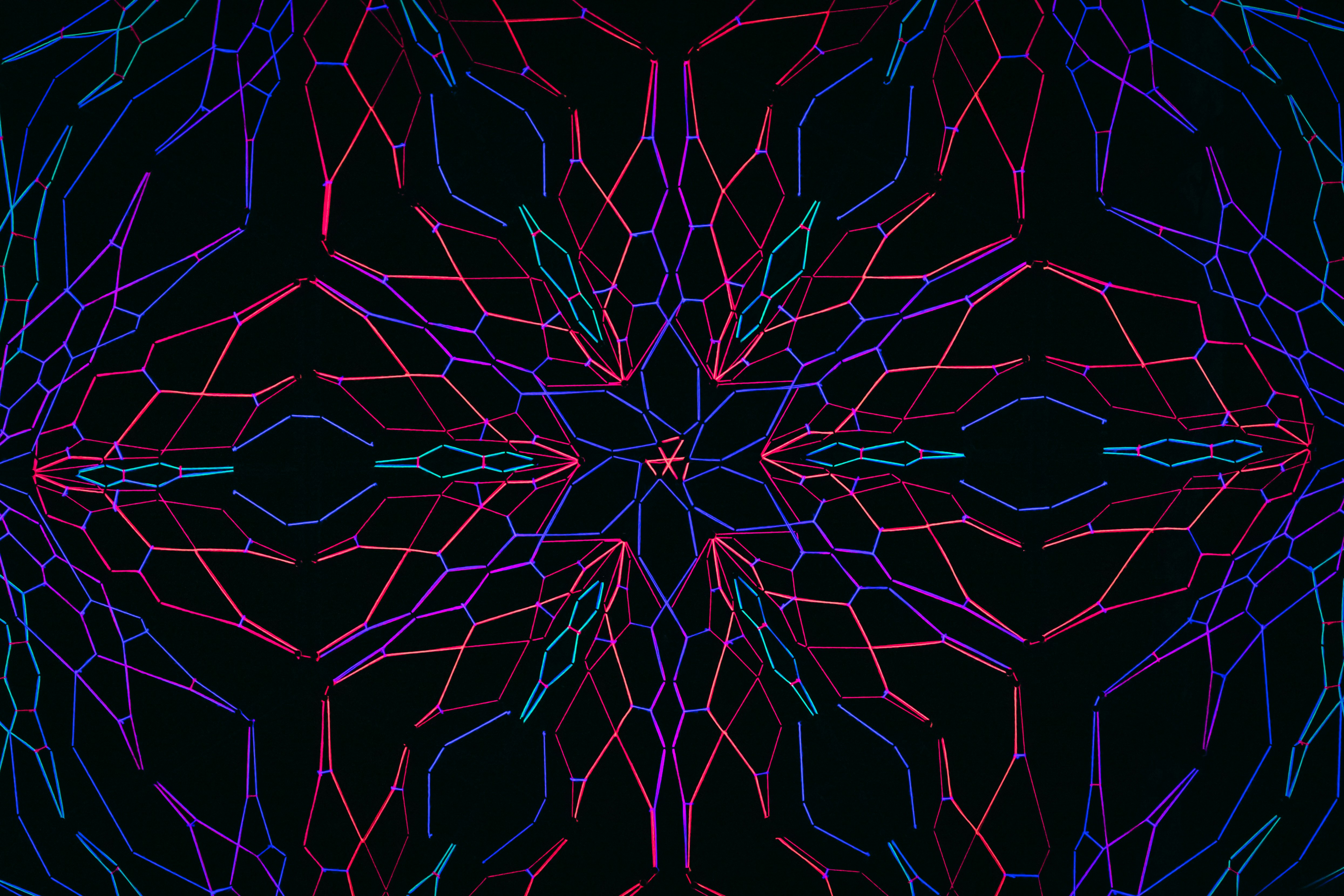 Intricate neon patterns intertwine against a dark backdrop, creating a mesmerizing geometric design. This digital illustration showcases vibrant colors and symmetrical shapes.