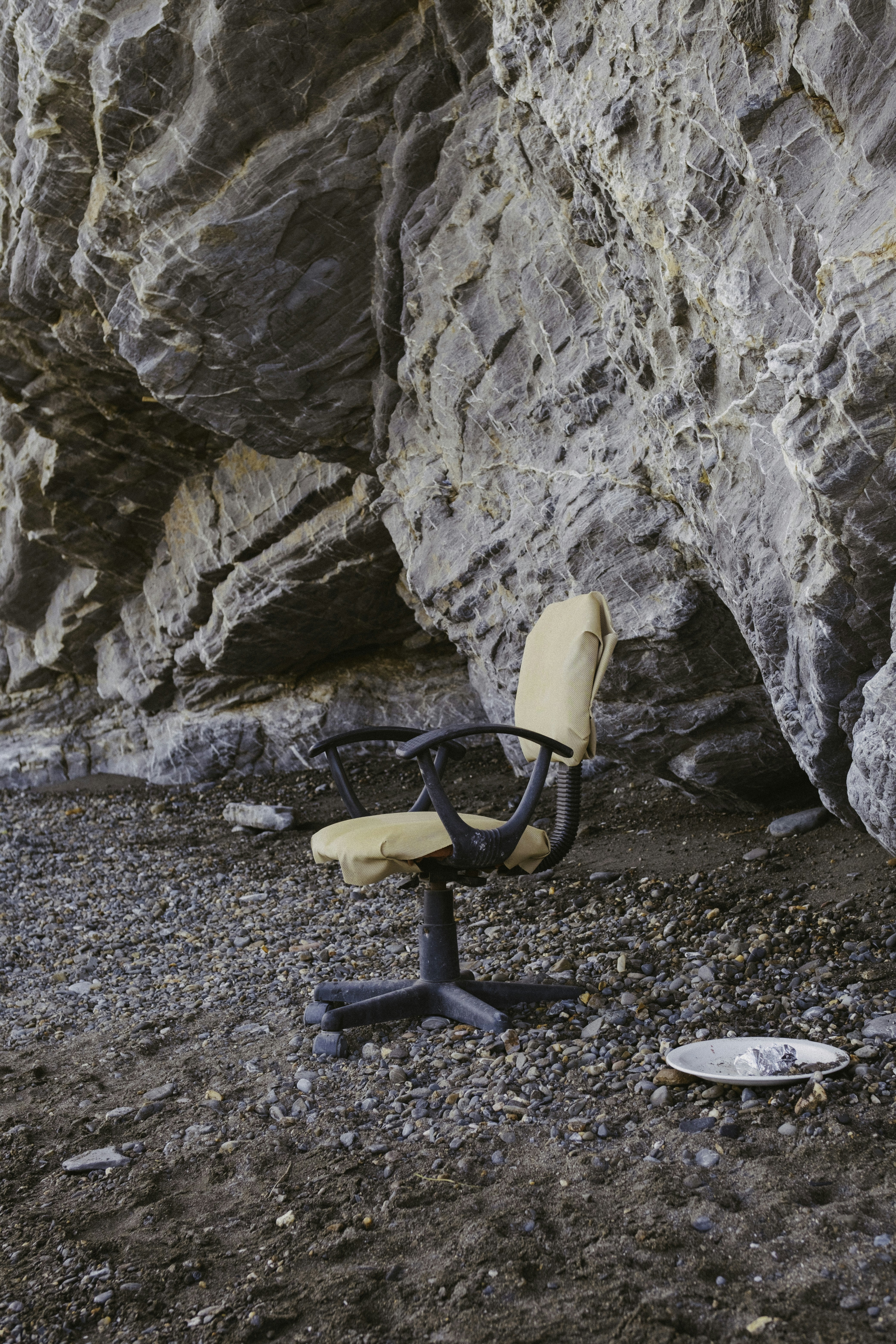 Deserted Office Chair Finds Solace Beneath a Rocky Overhang