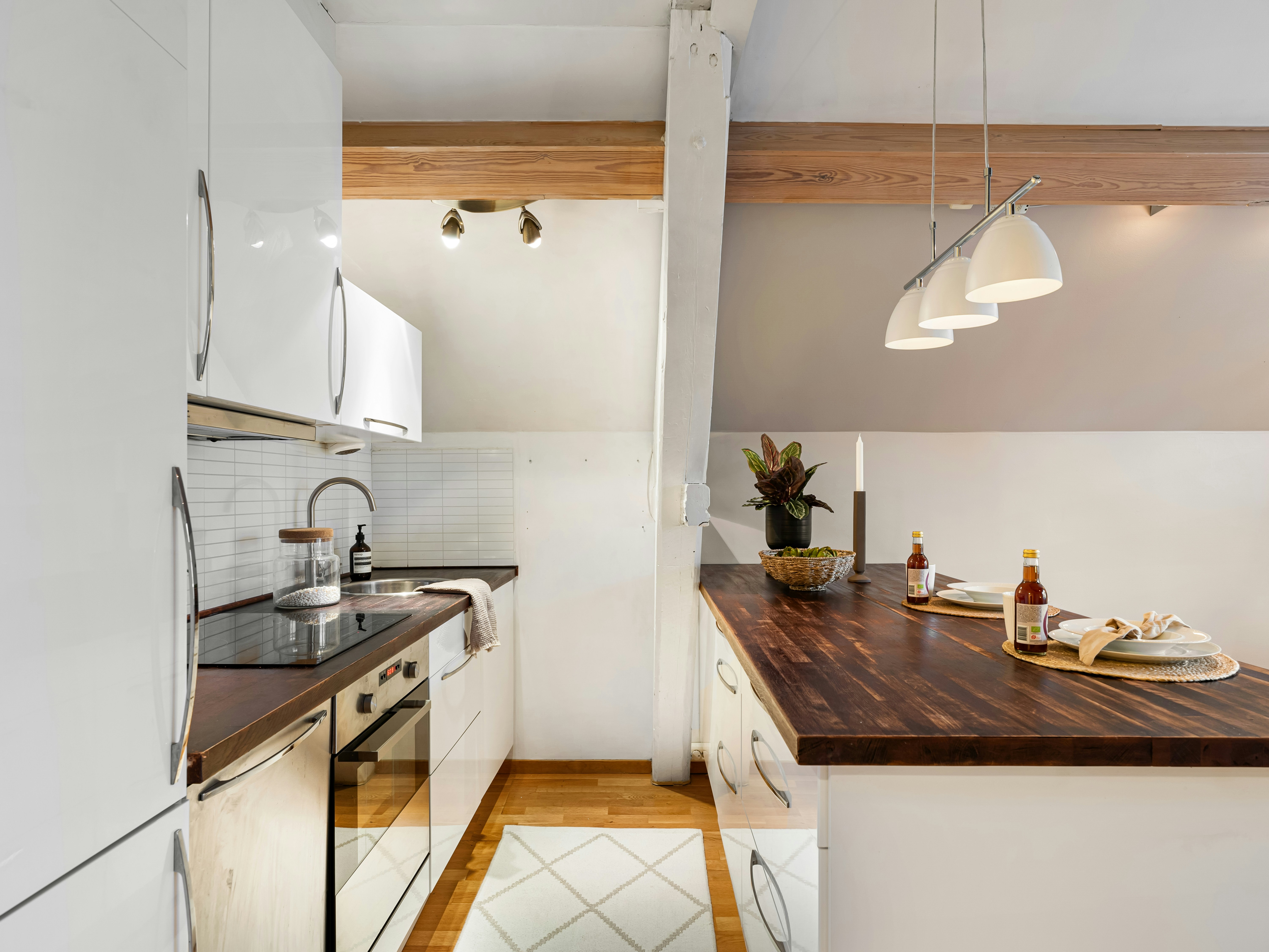 A kitchen with a wooden counter top and white cabinets photo – Free ...