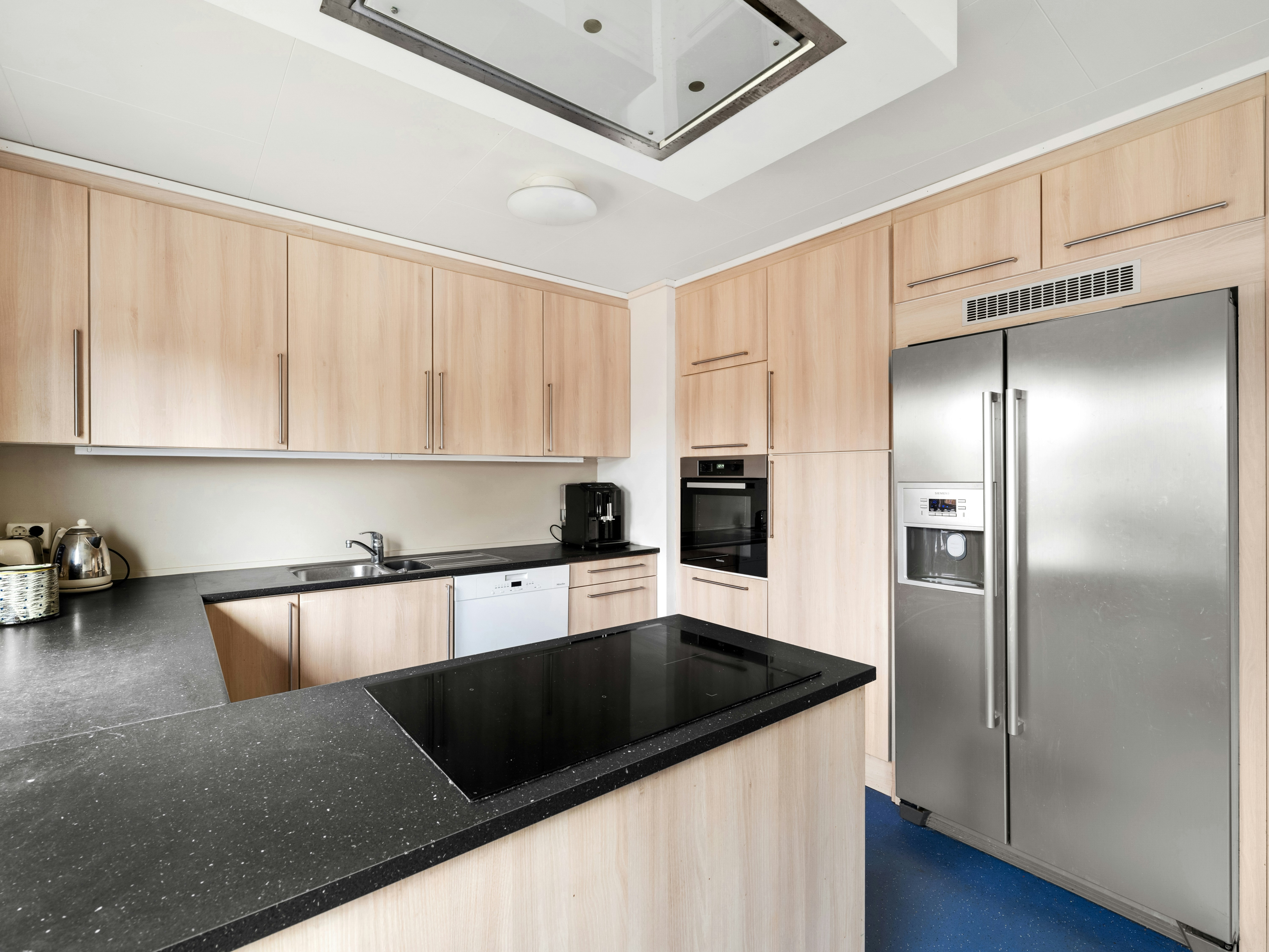 Una cocina con un refrigerador con congelador junto a un horno de ...