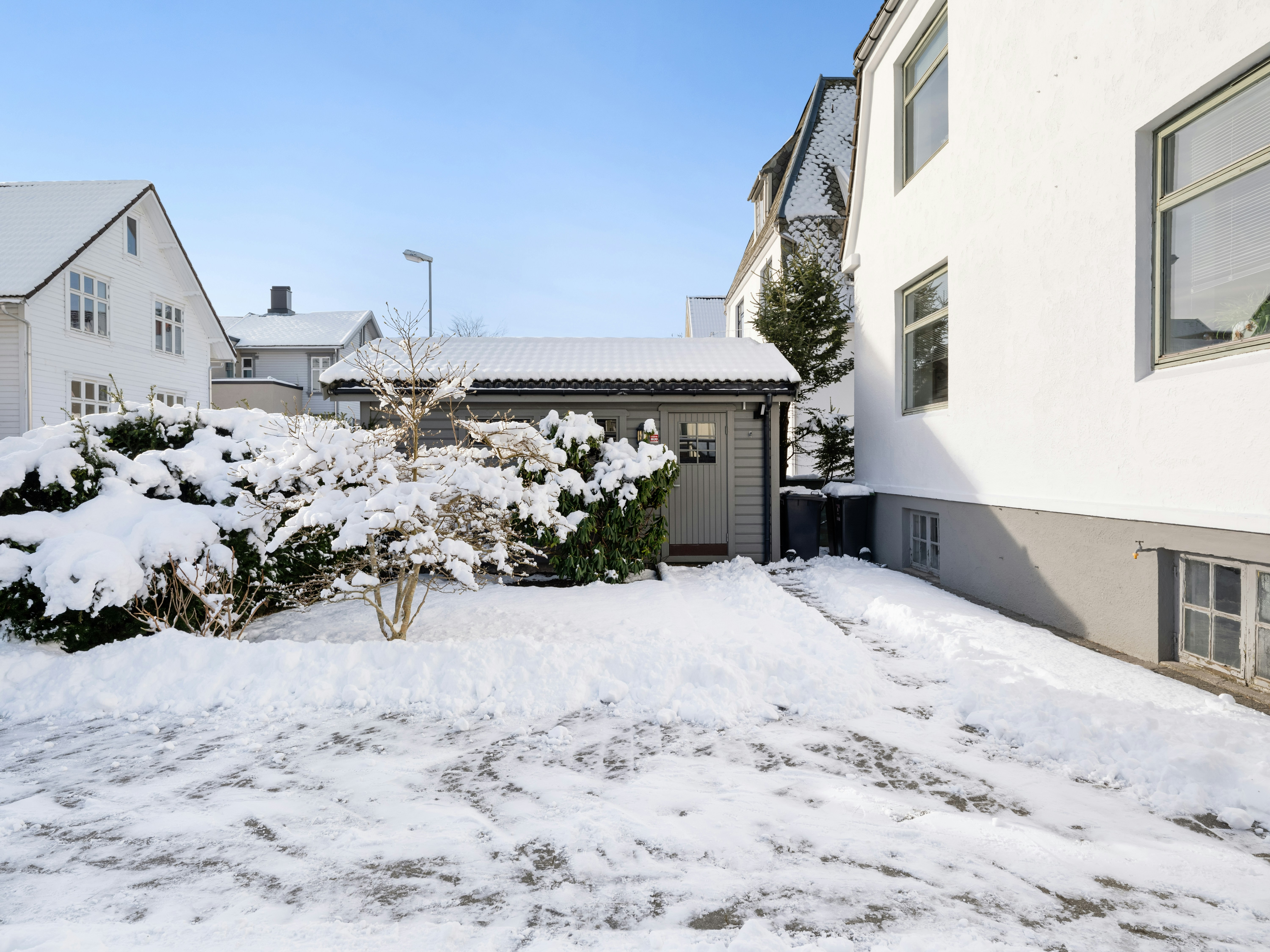 A snow covered yard next to a white building photo – Free Neighborhood ...
