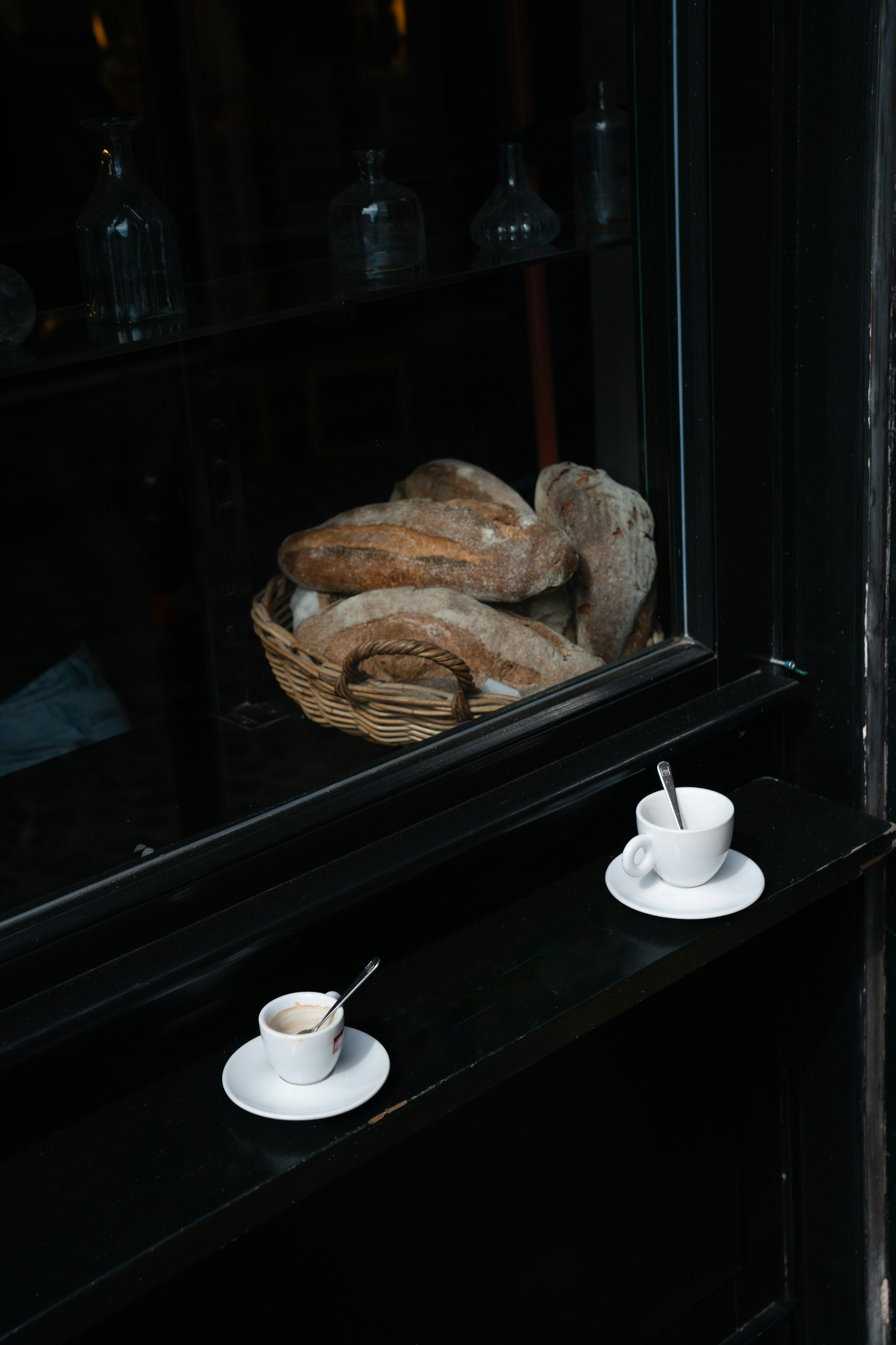 Crust Behind the Glass: a bread basket in a dim cafe window