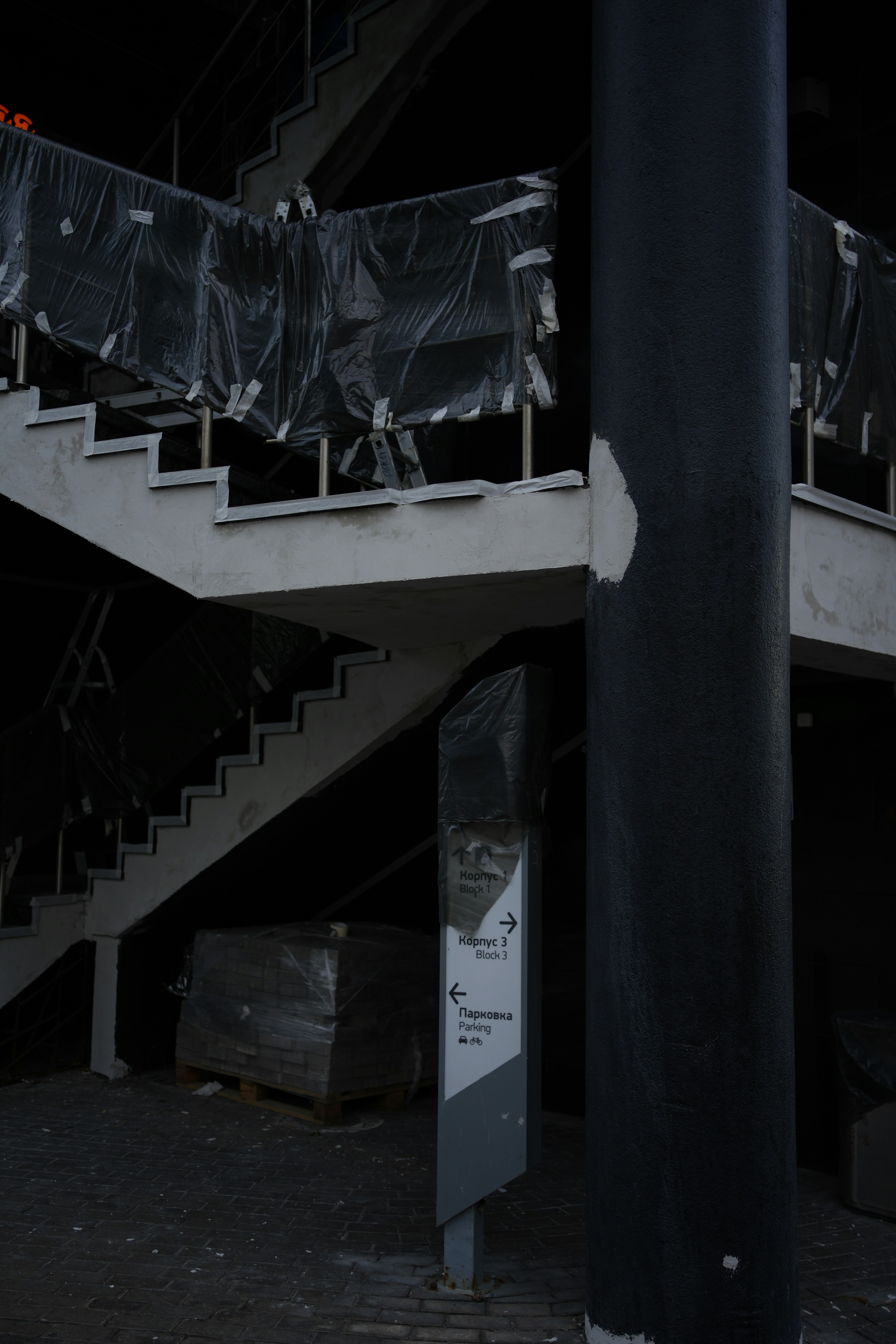 Hidden Pathways: Plastic-Wrapped Staircase under a Monolithic Column
