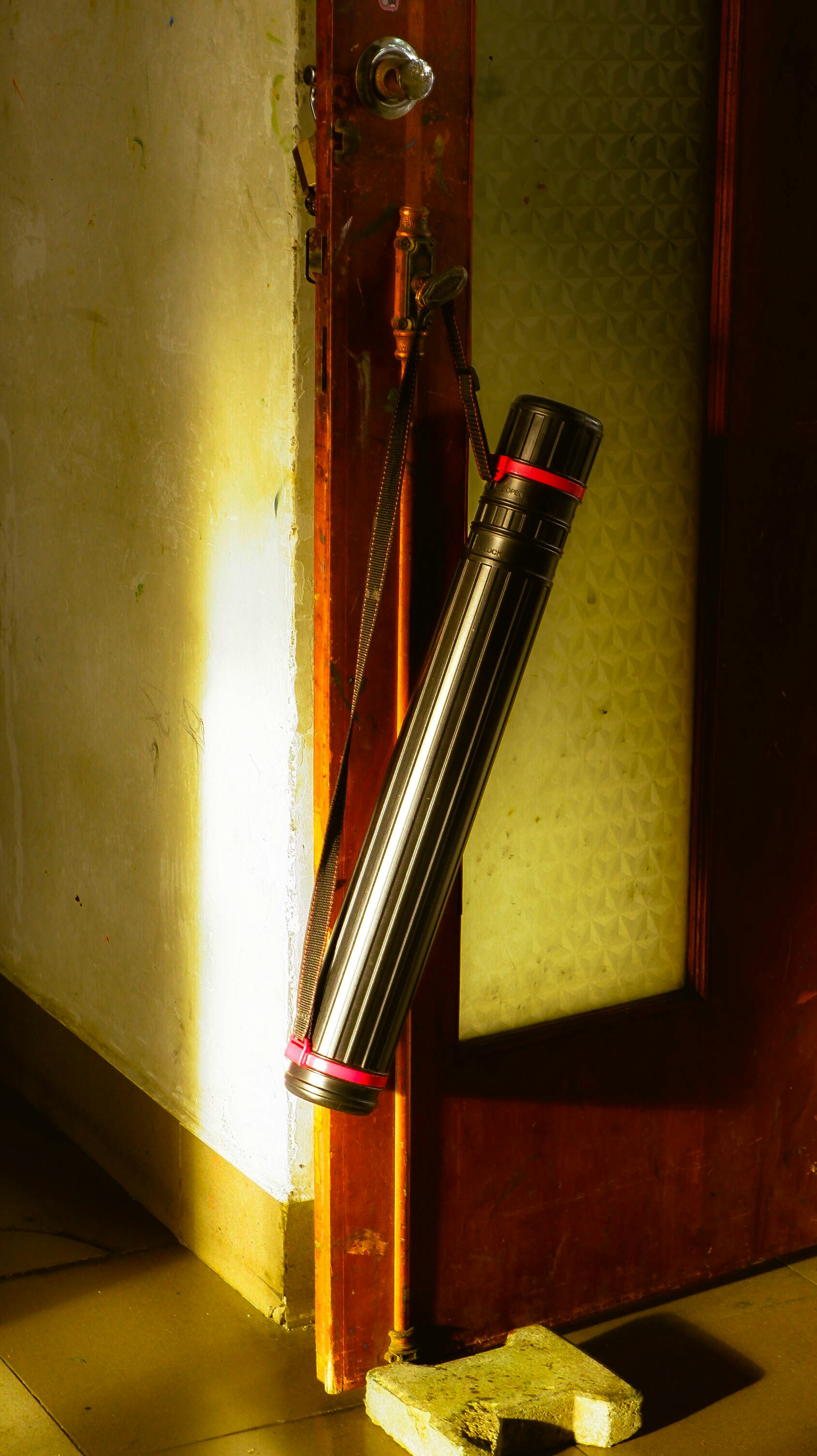 A flashlight sitting on the floor next to a door photo – Free Lamp ...