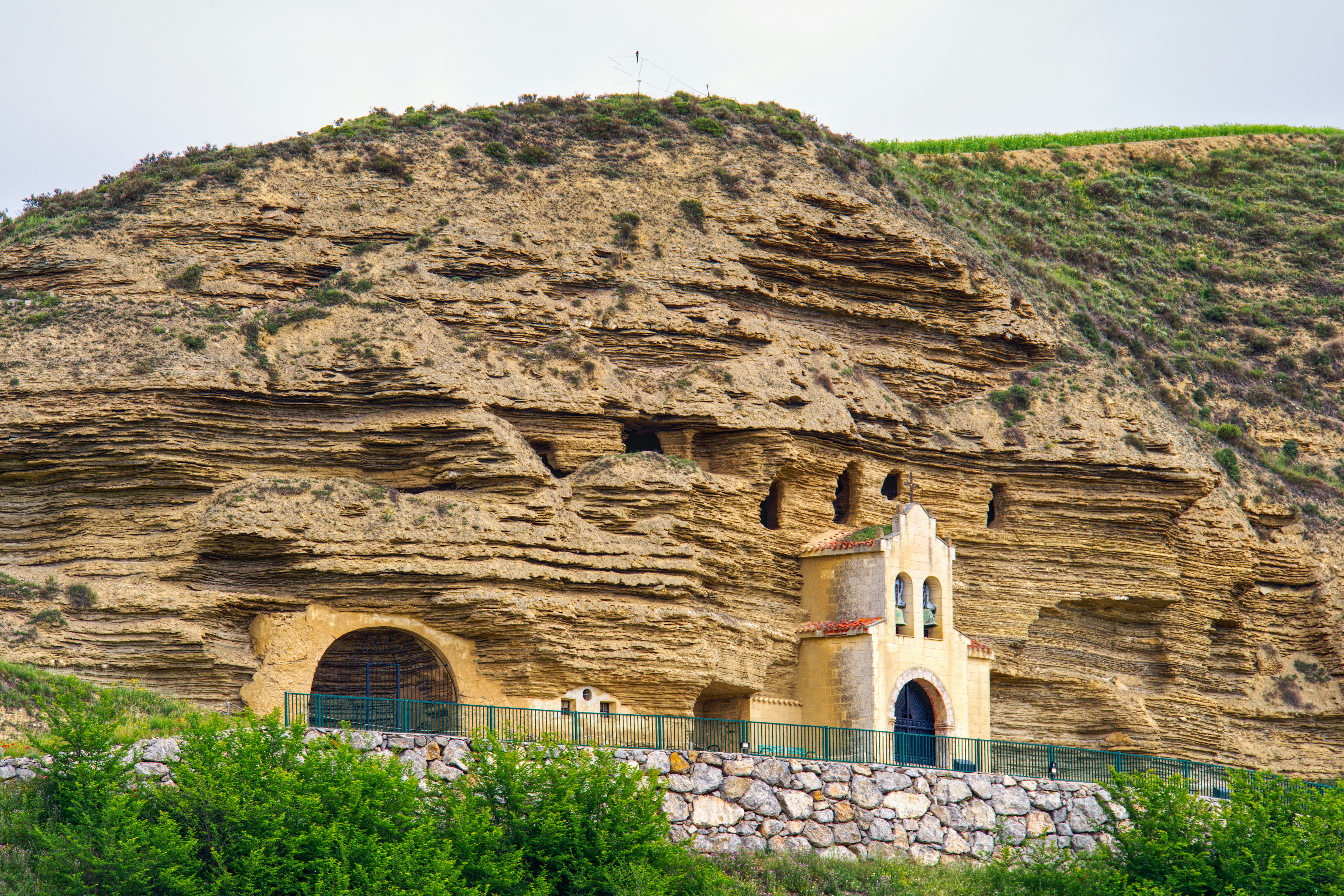 Stone-Sculpted Sanctuary: A Cliffside Chapel Nestled in Layered Rock
