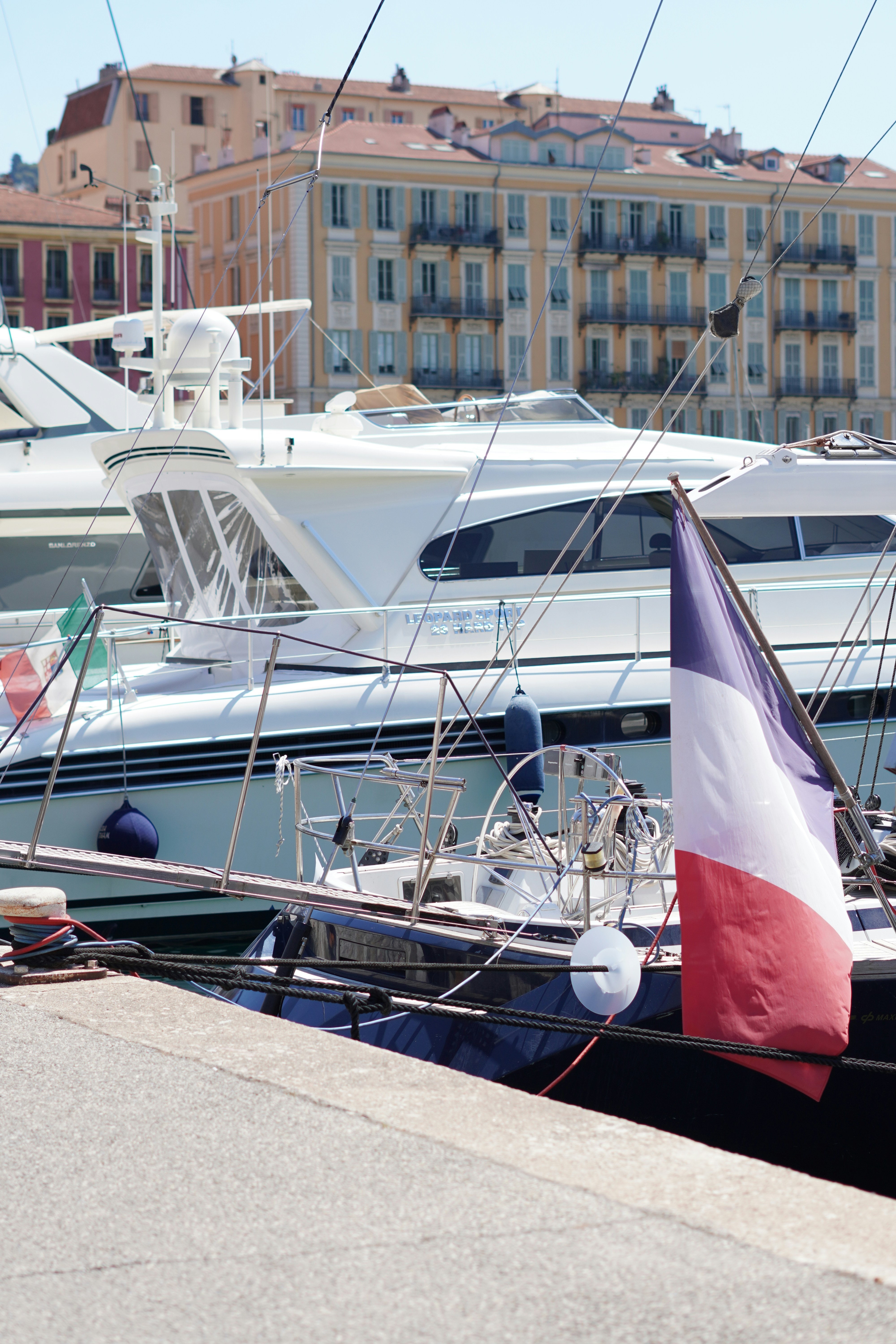 Harbor Symphony: White Yachts, Wires, and a French Flag in the Sun