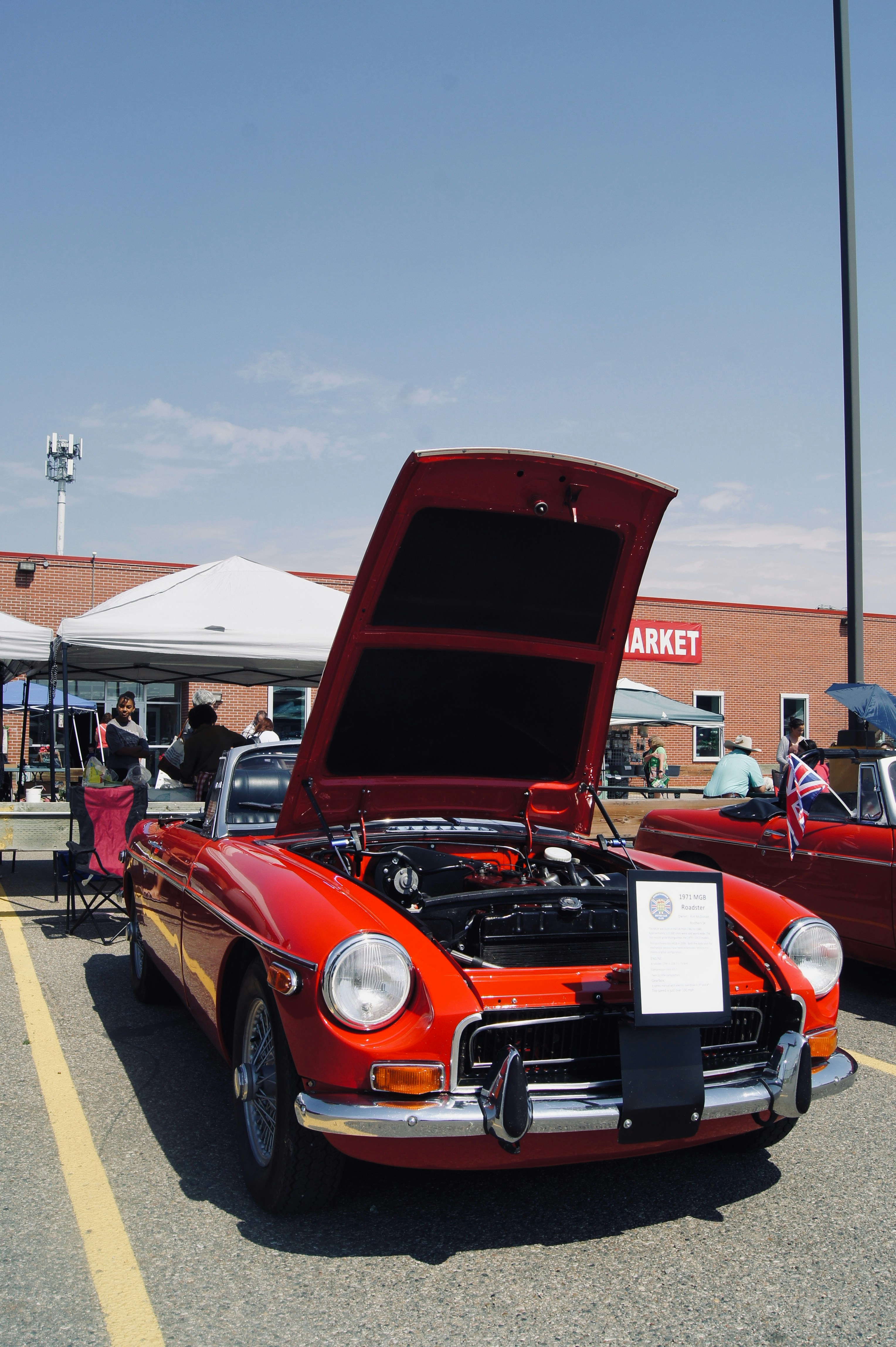 Red Jaguar Classic at a Car Show: Hood Open, Engine Display under Clear Sky
