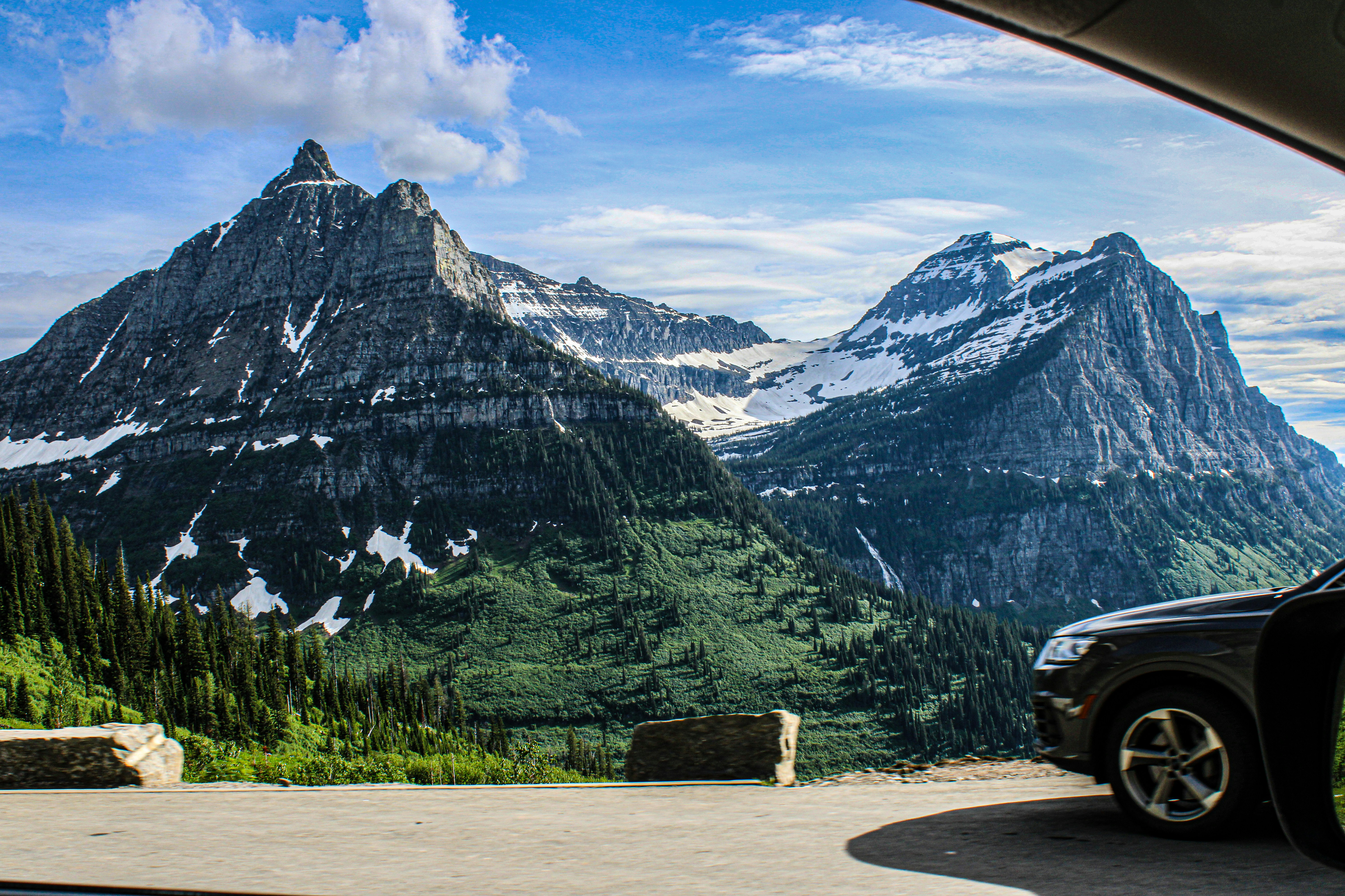 Alpine Perspective: Snow-Capped Peaks Framed by a Parked Car