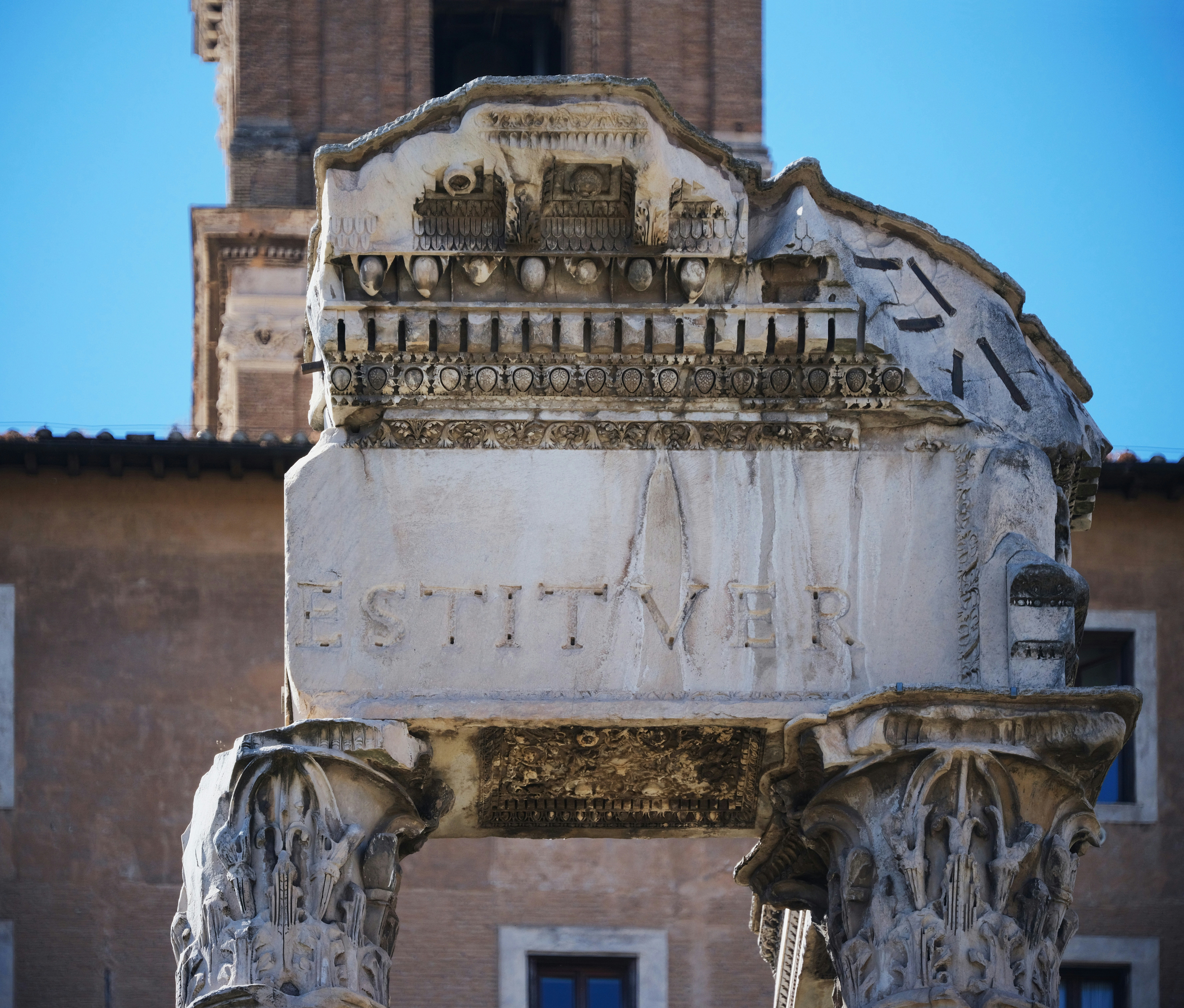 Carved Crown Under a Cerulean Sky: Ornate Columns Guard a Timeworn Monument
