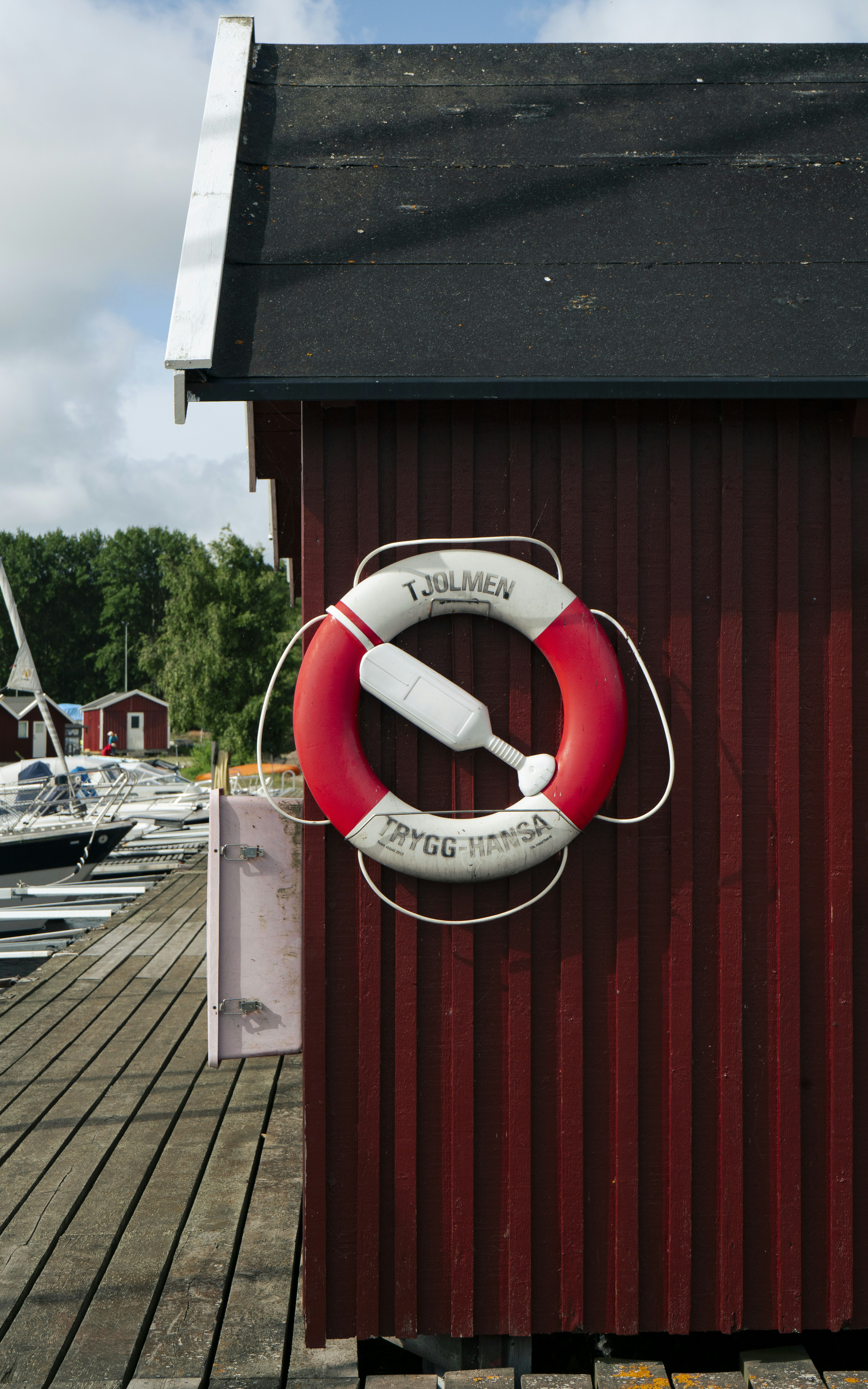 Harbor Lifebuoy on a Weathered Red Boathouse