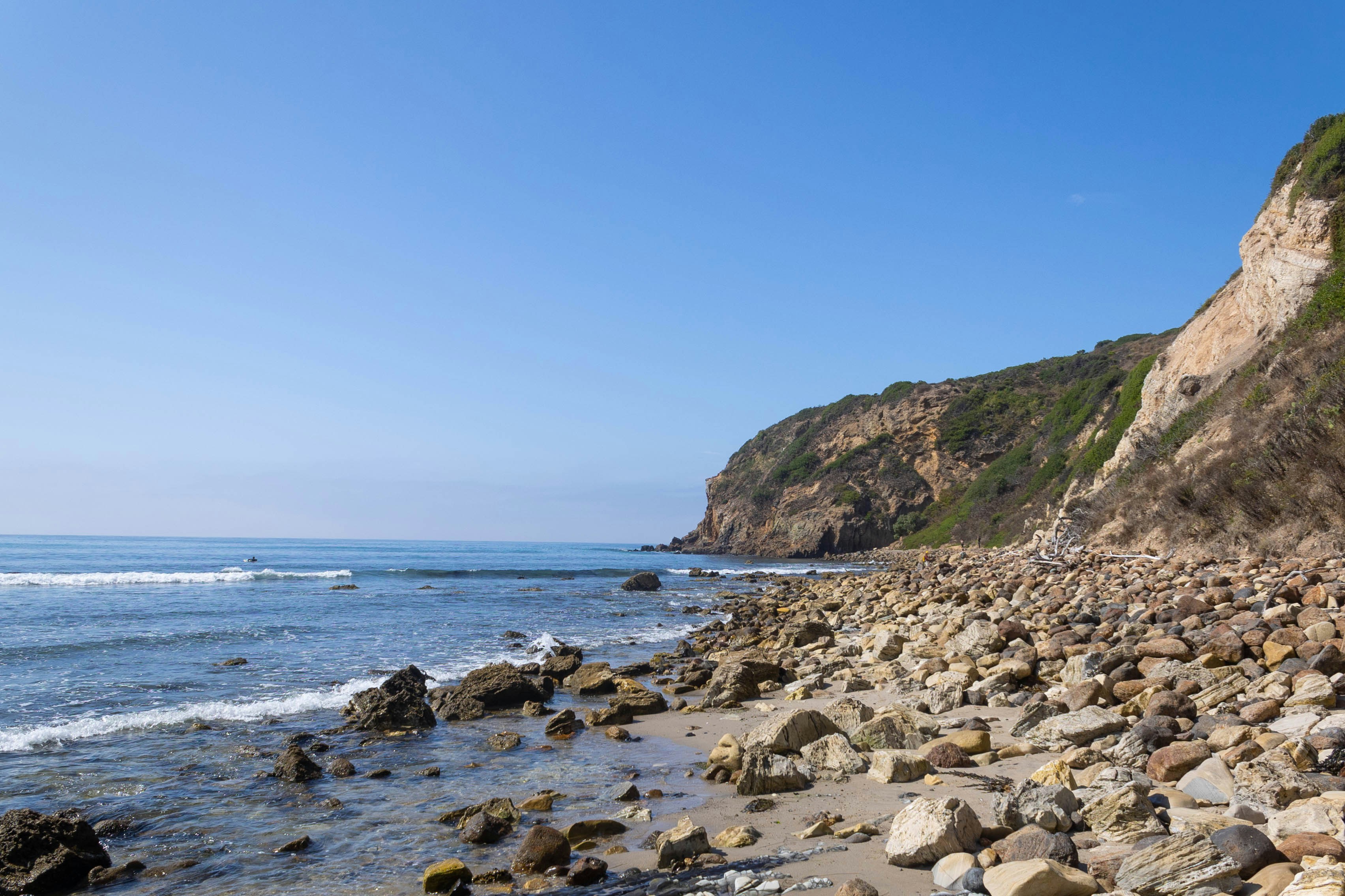 Una playa rocosa junto al océano bajo un cielo azul foto – Imagen de ...
