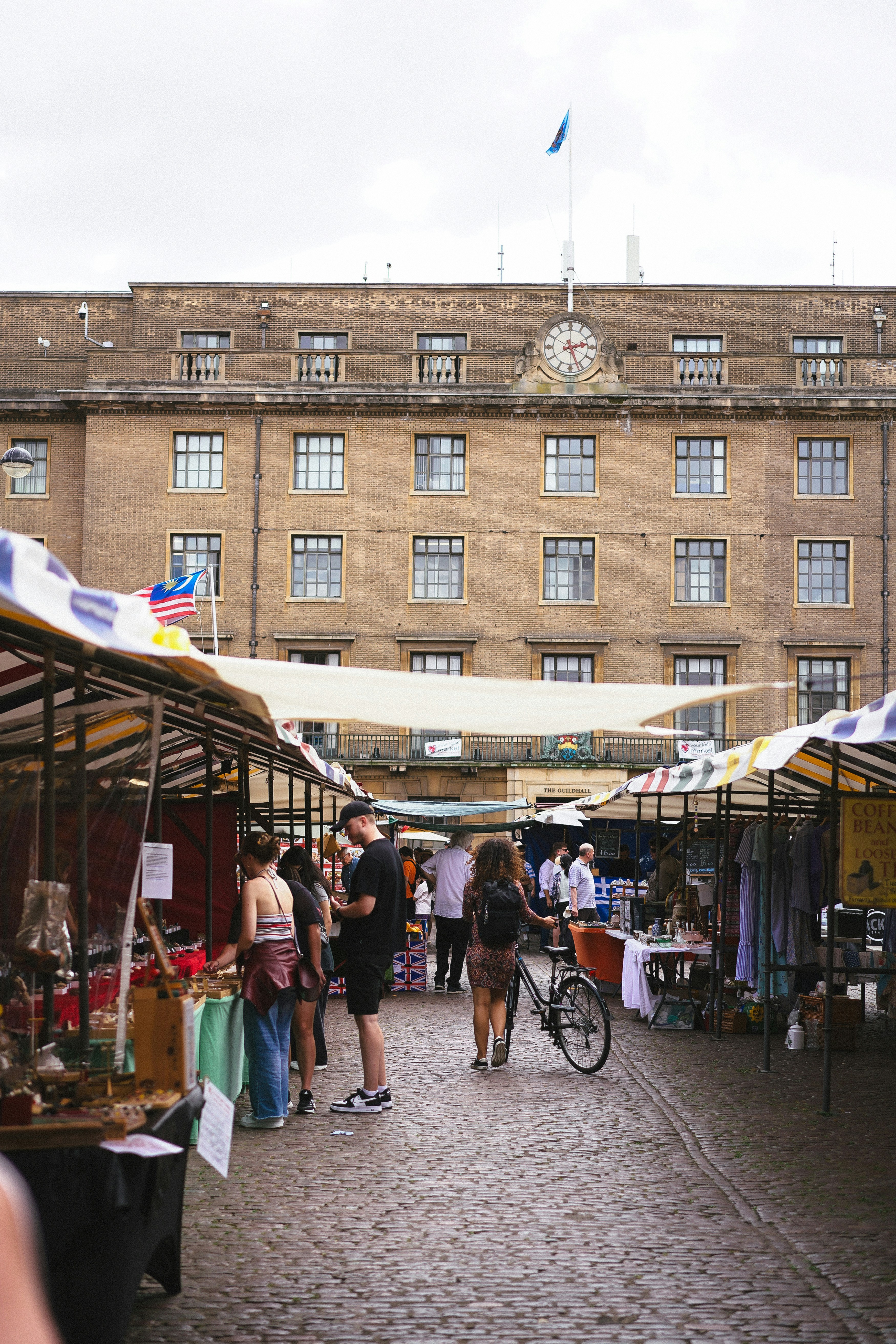 Clock-Faced Courtyard: Market Stalls Under a Brick Facade