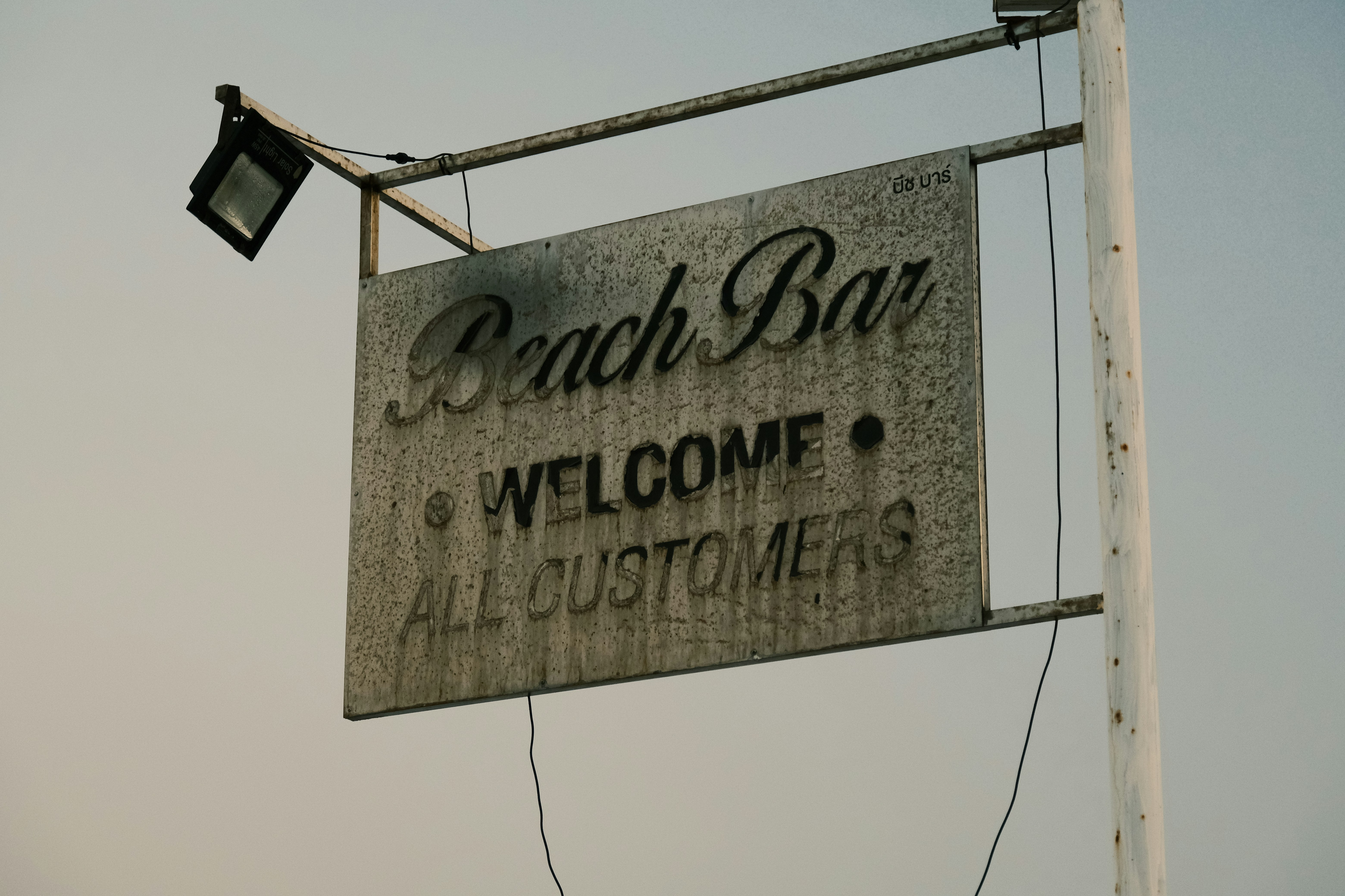 A welcome sign is hanging from a light pole photo – Free Sign Image on ...