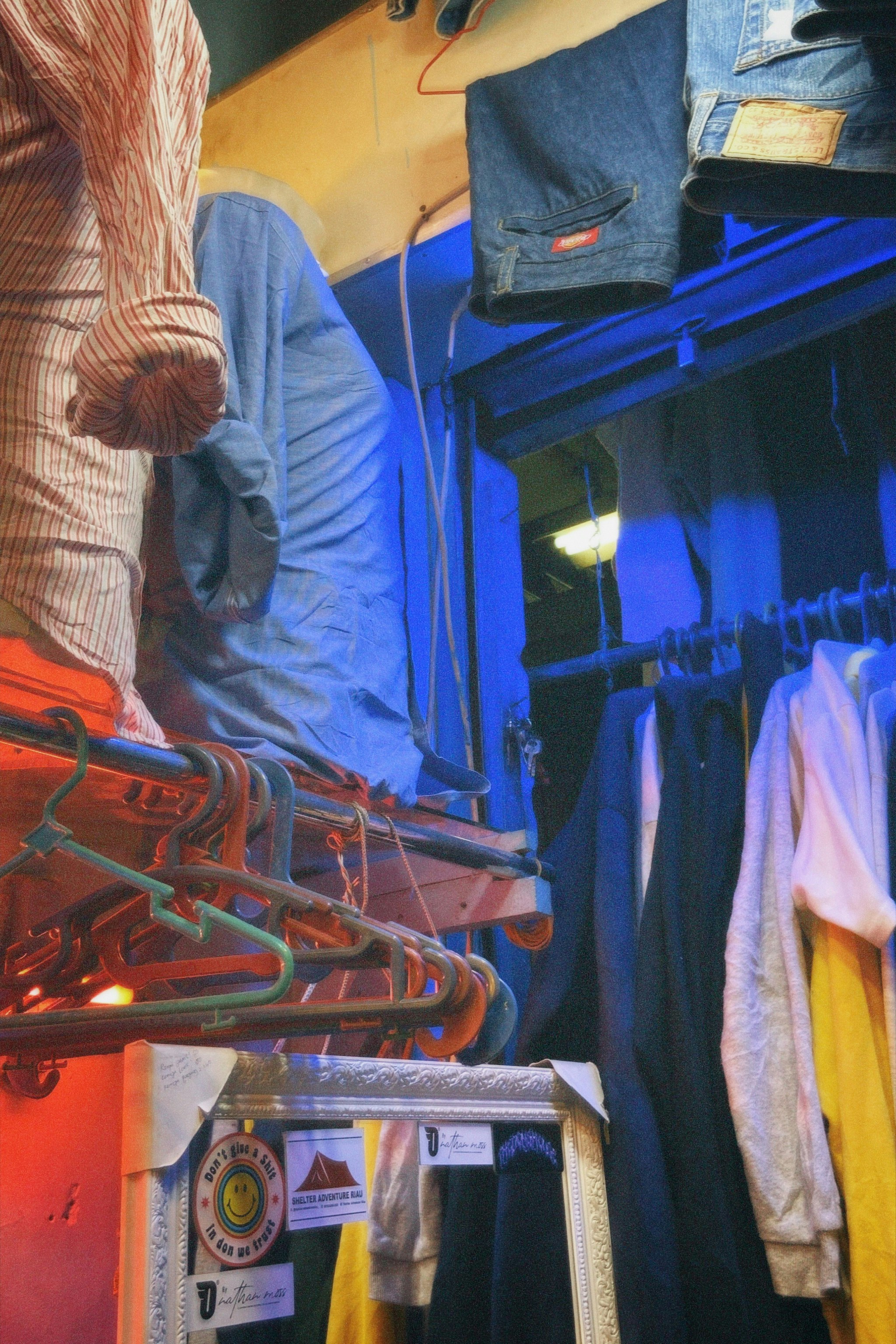 Cobalt Wardrobe Under Neon: Hangers, Mirror, and a Quiet Smile