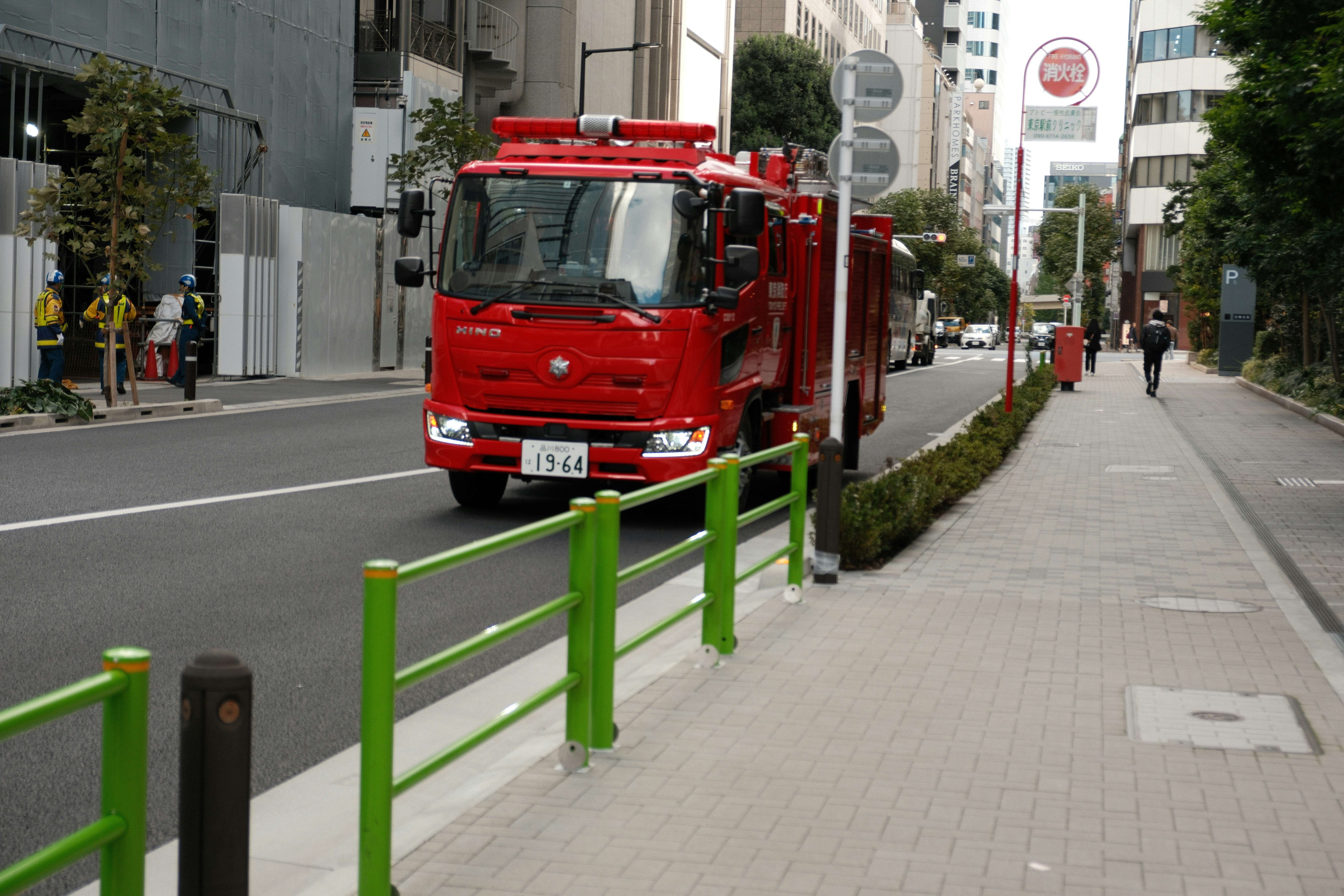 Red Engine on Neon-green Rails: A City Street in Motion