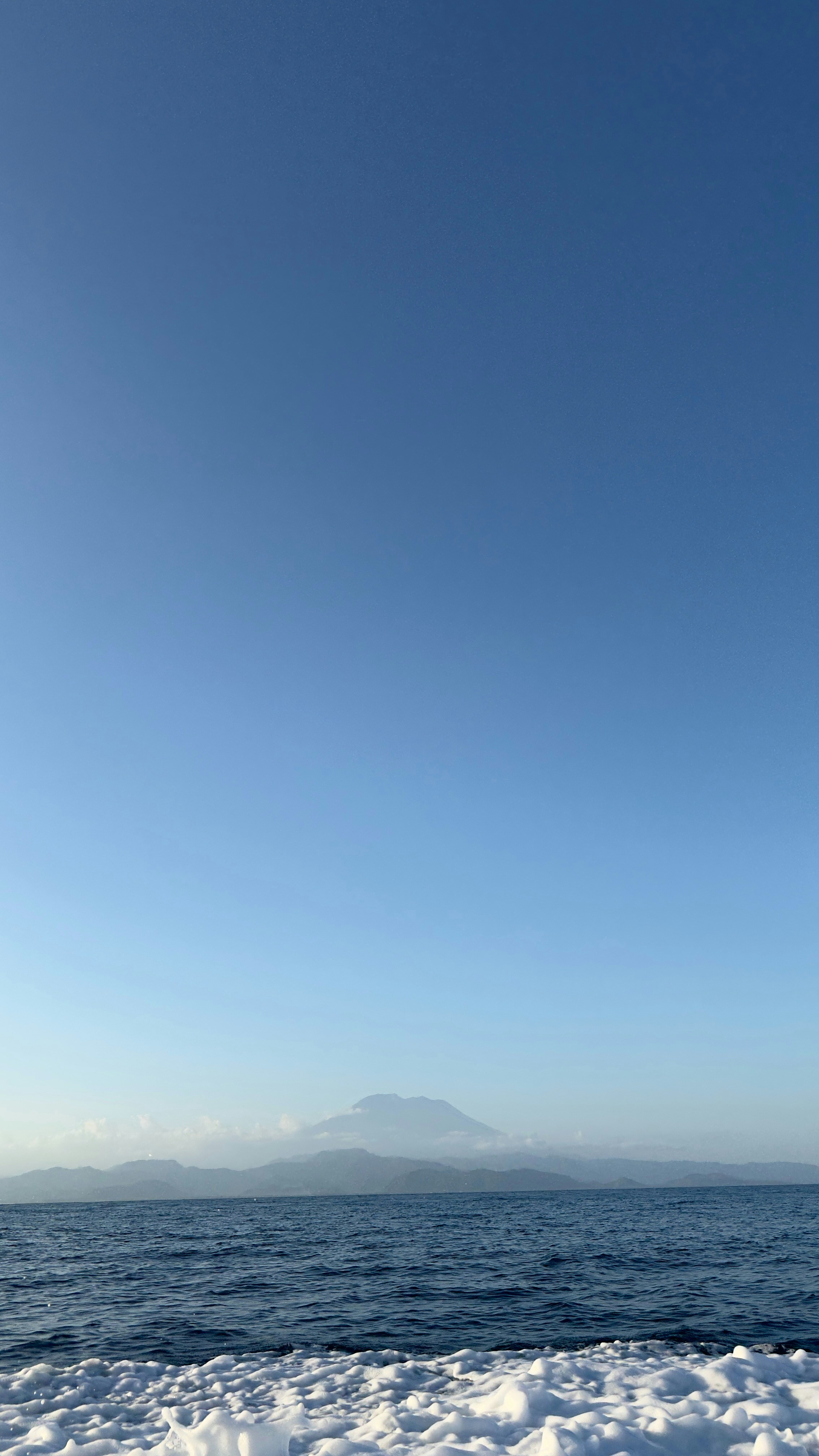 Distant Volcanic Peak on a Snow-White Foreshore