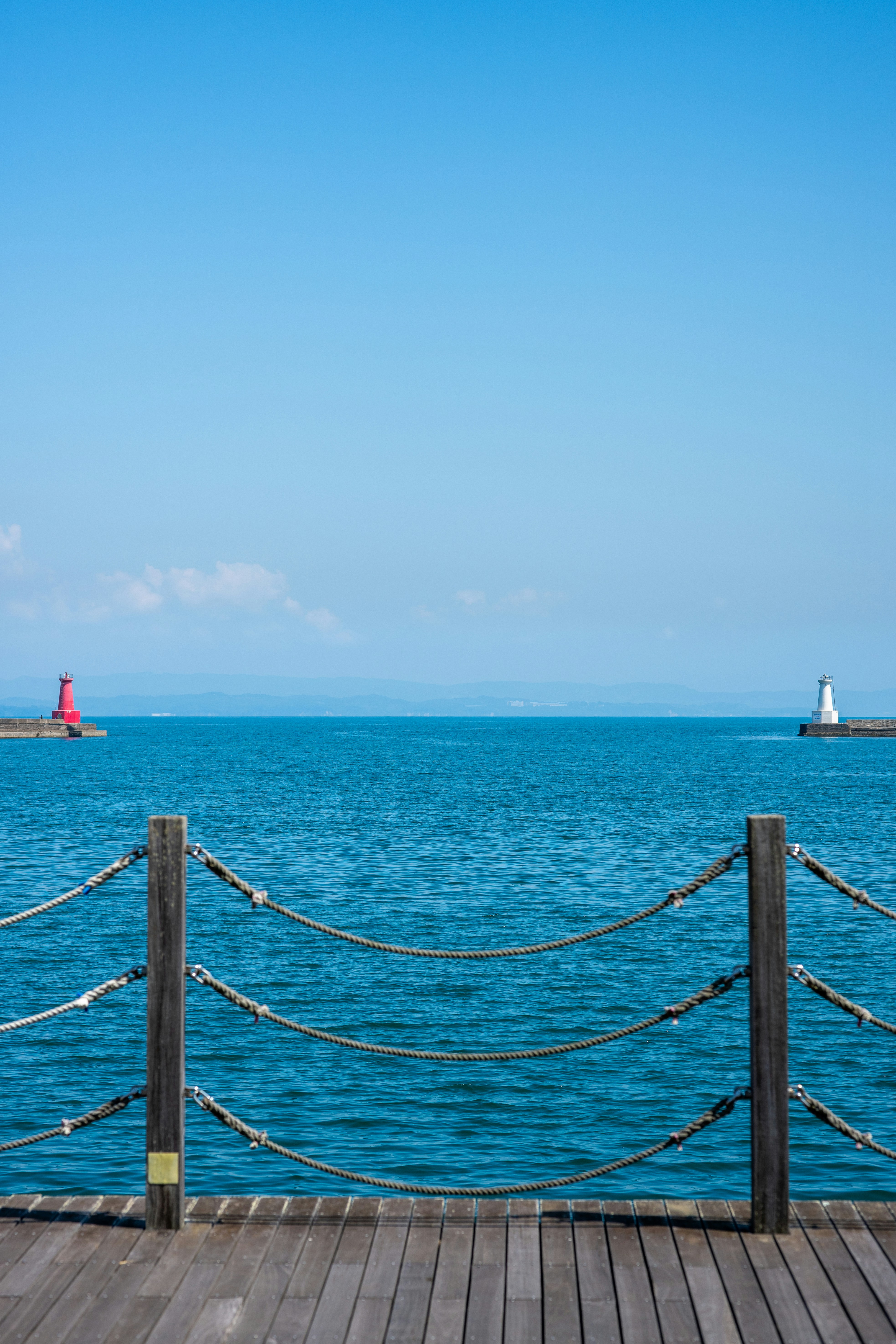 A wooden dock with a lighthouse in the distance photo – Free Nature ...