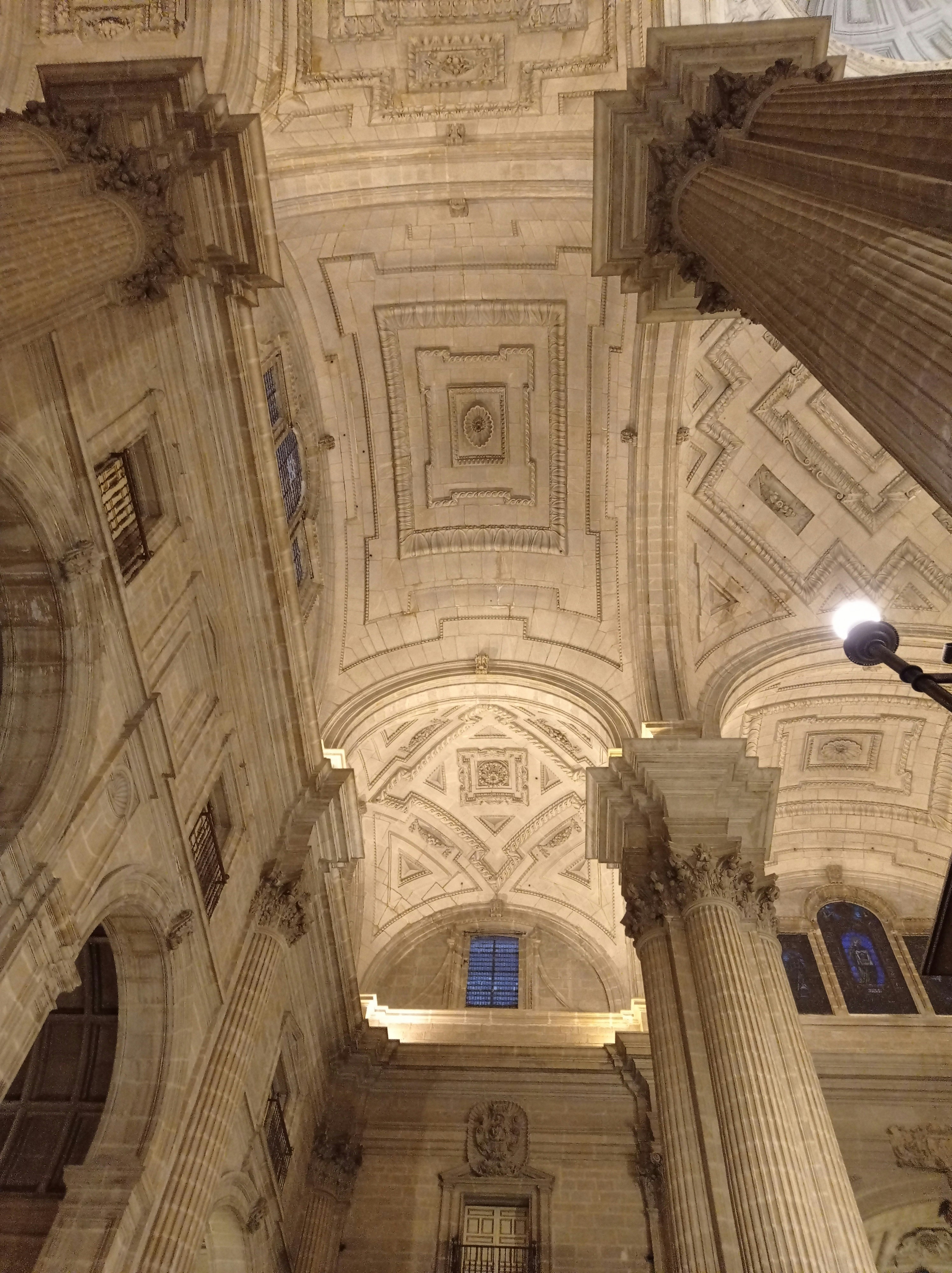 Intricate stonework of a cathedral ceiling with geometric patterns and towering columns.