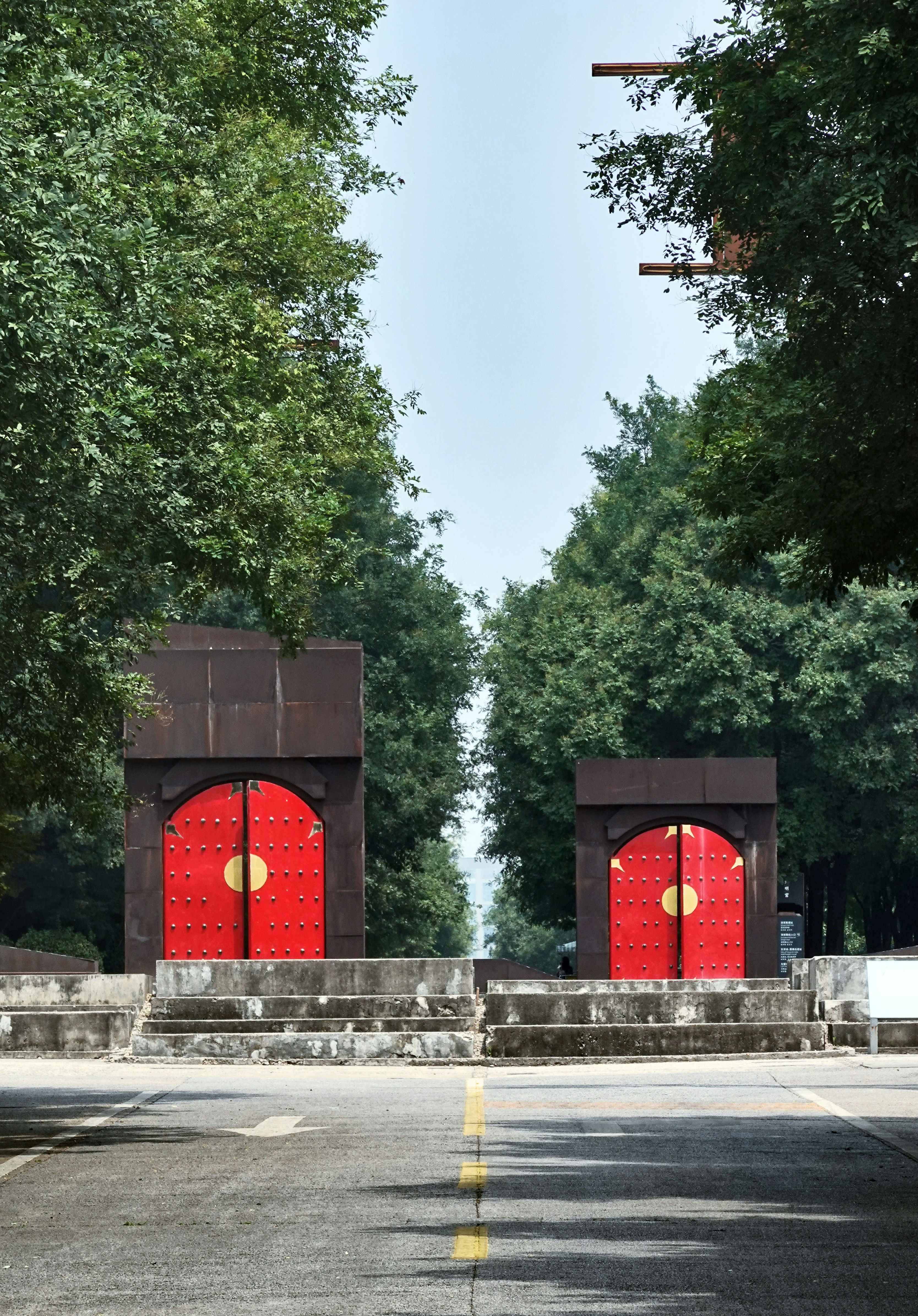 Scarlet Gates at the End of a Tree-Lined Avenue
