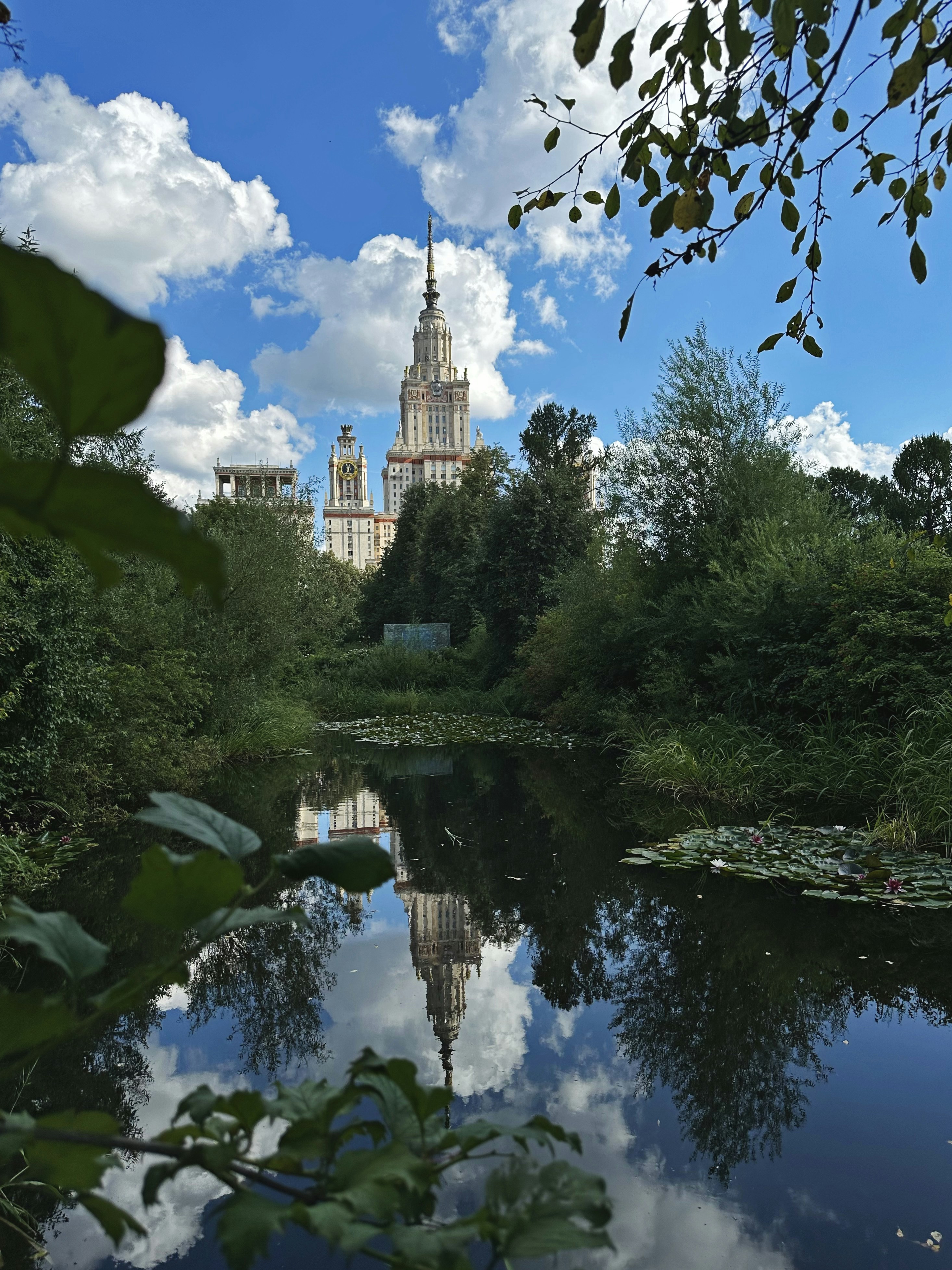 Spire Over Still Water: A City Park Reflection