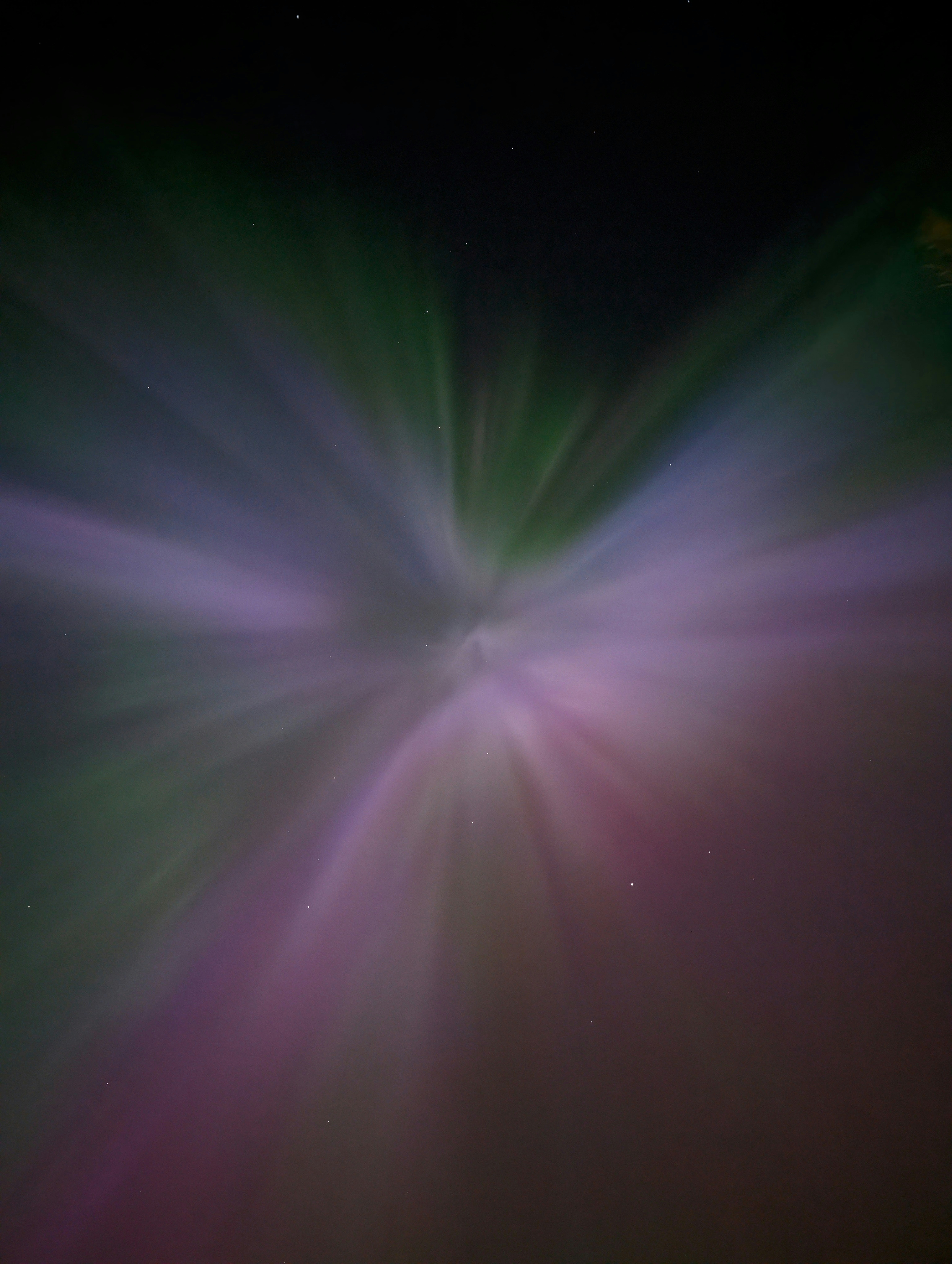 Centerburst Aurora: Green and violet ribbons radiate from the night's heart
