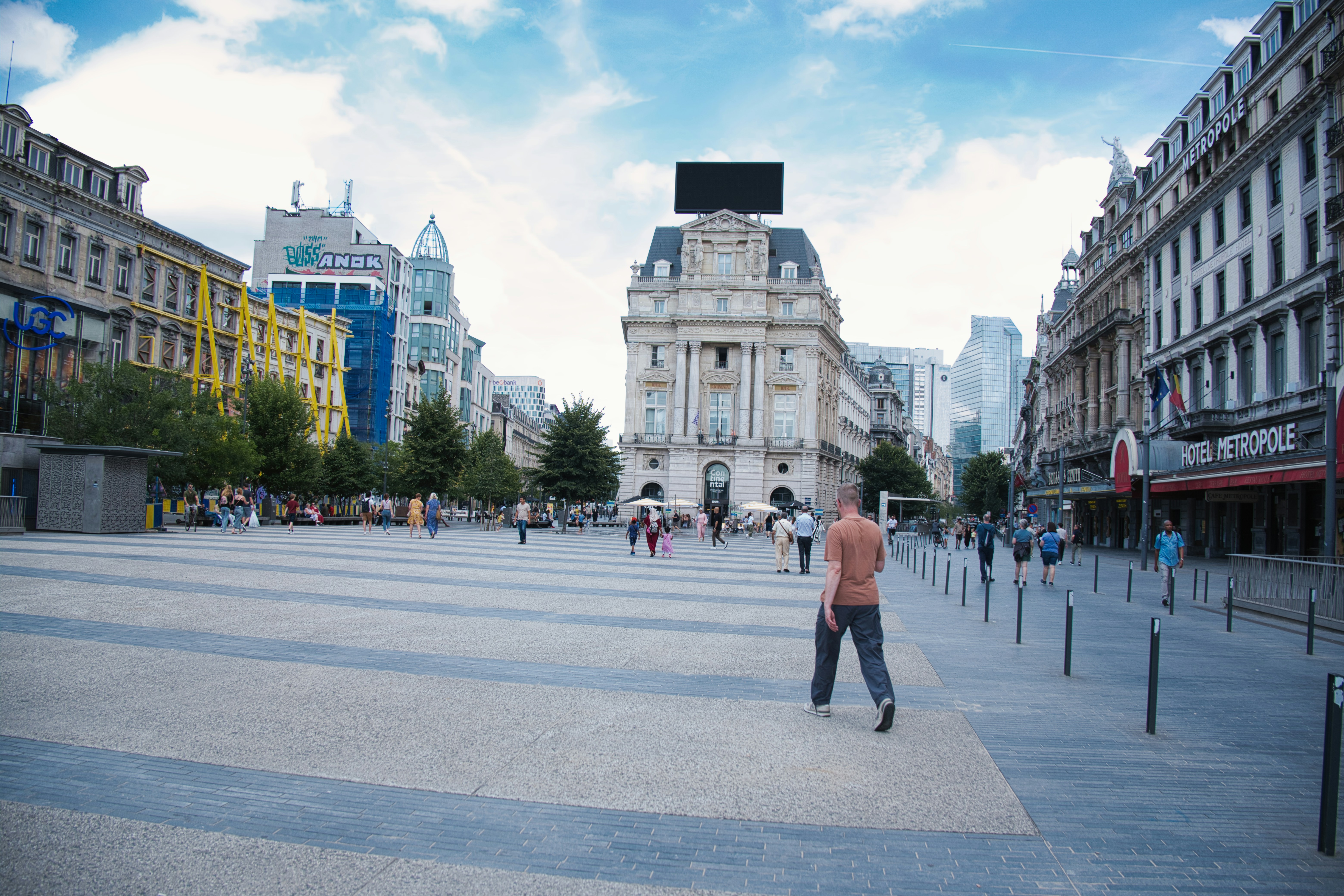 Footsteps Toward the Facade: A Lone Figure in a Sunlit City Plaza