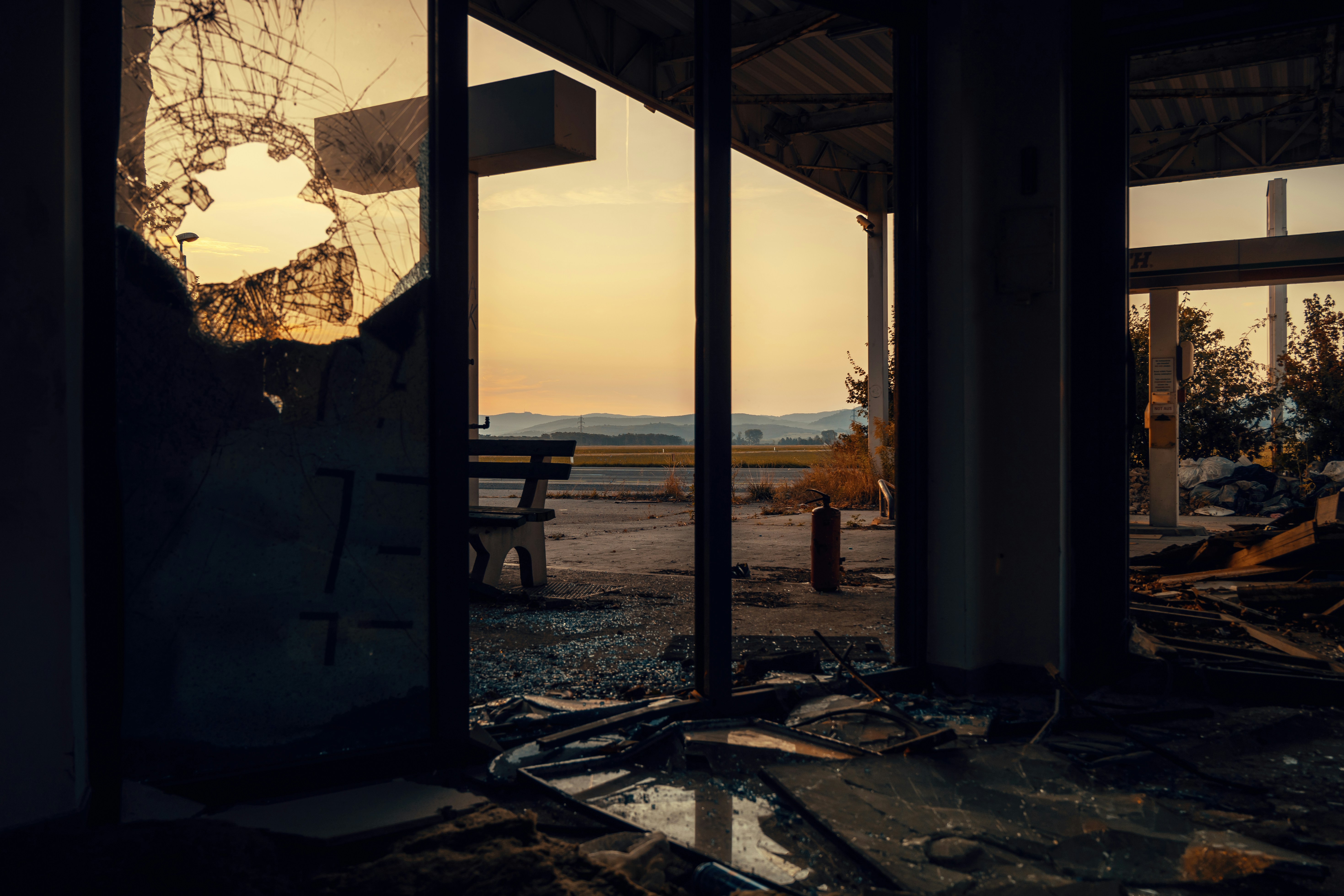 A broken down building with the sun setting in the background photo ...