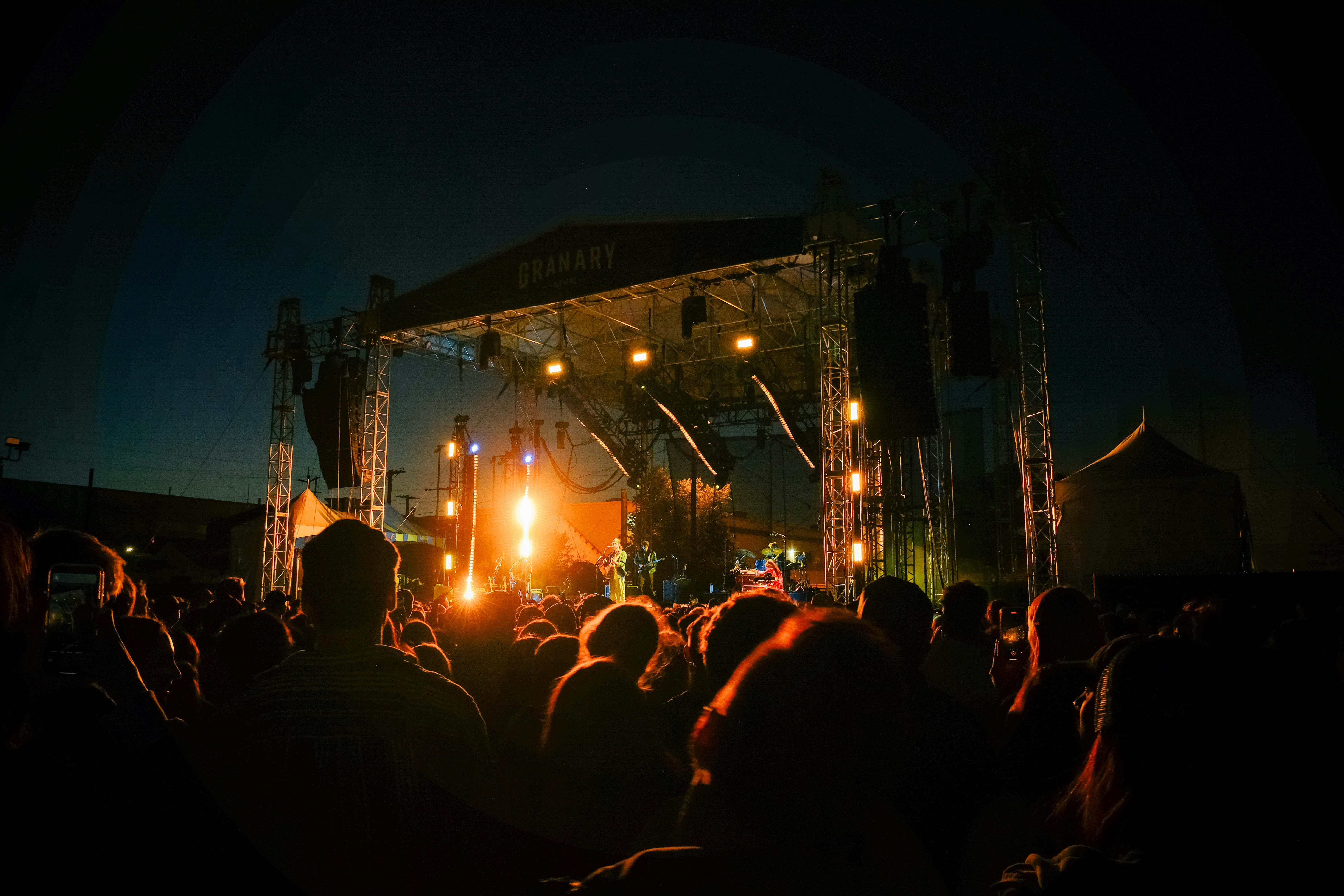 A crowd of people standing around a stage at night photo – Free Concert ...