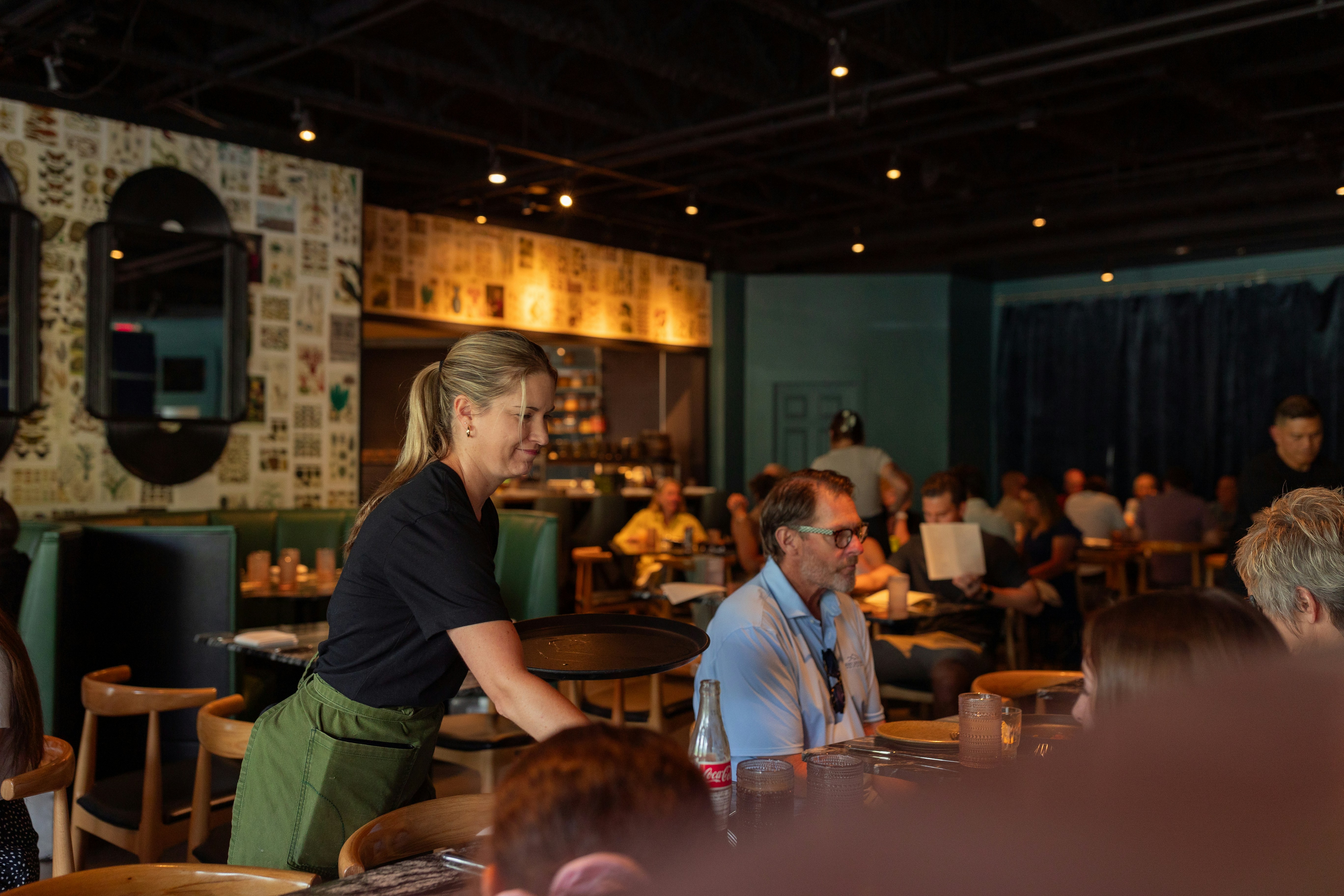 A group of people sitting at tables in a restaurant photo – Free ...
