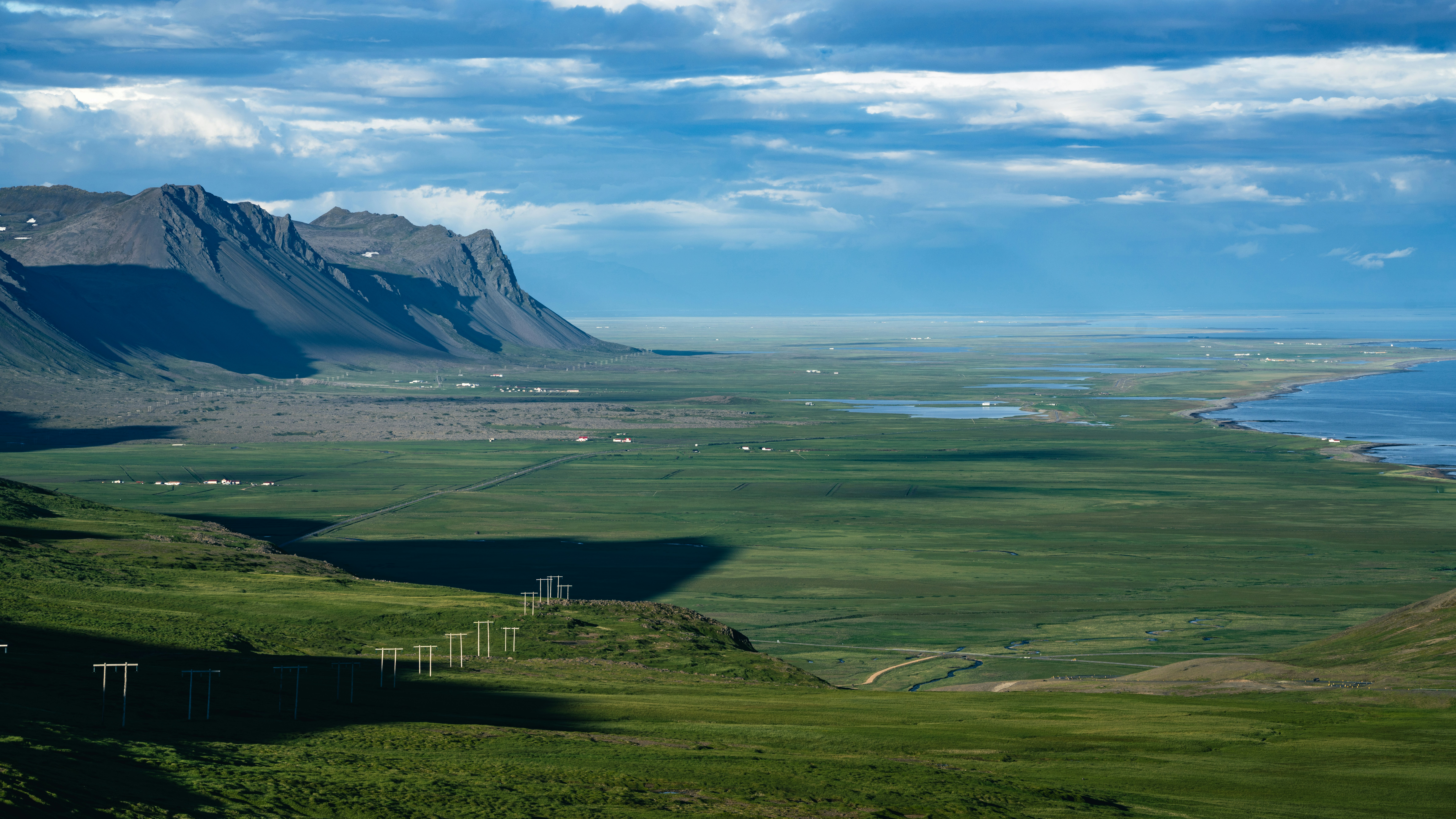 Emerald Plains Beneath a Looming Ridge and Meandering Coast