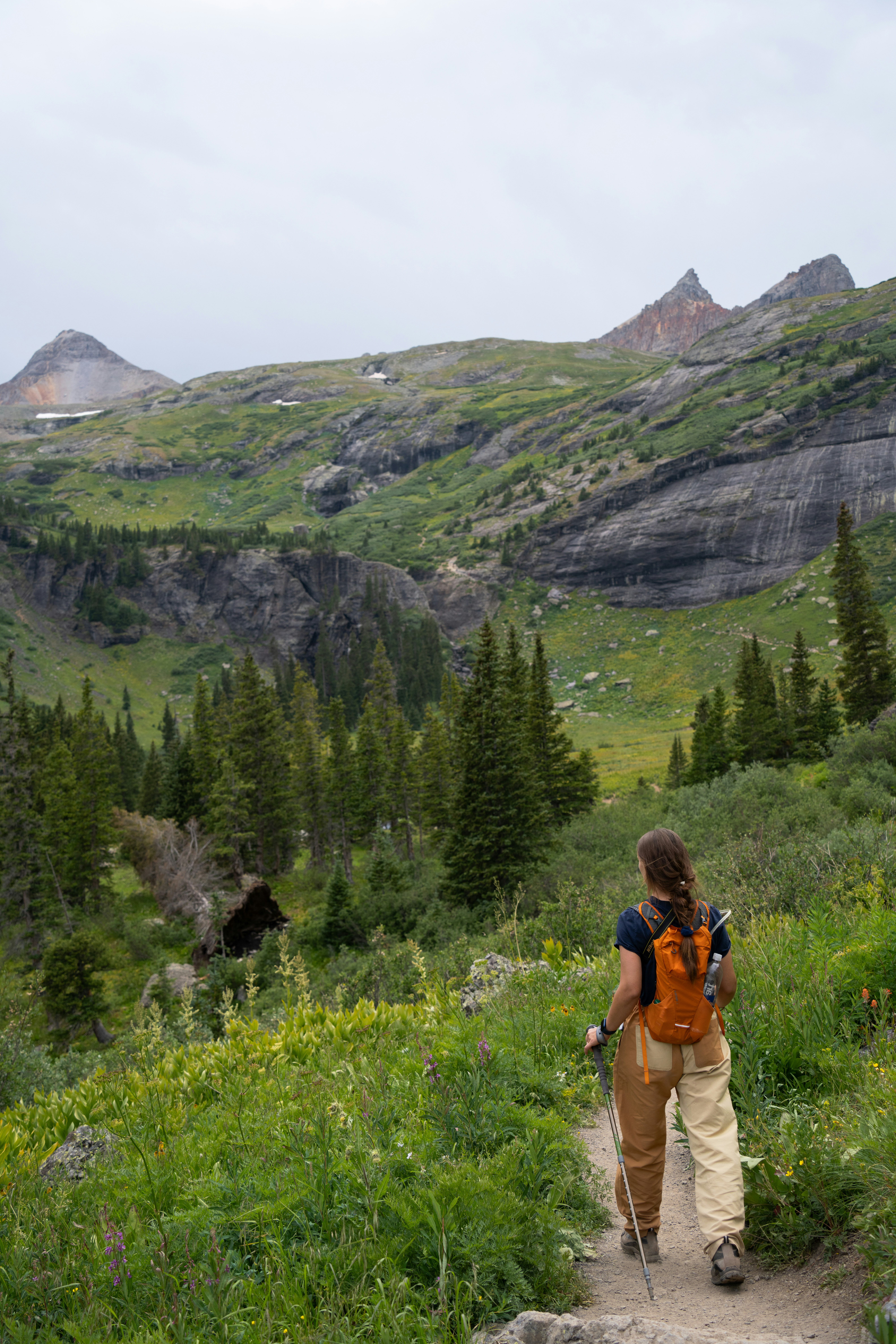 A woman hiking up a trail in the mountains photo – Free Nature Image on ...