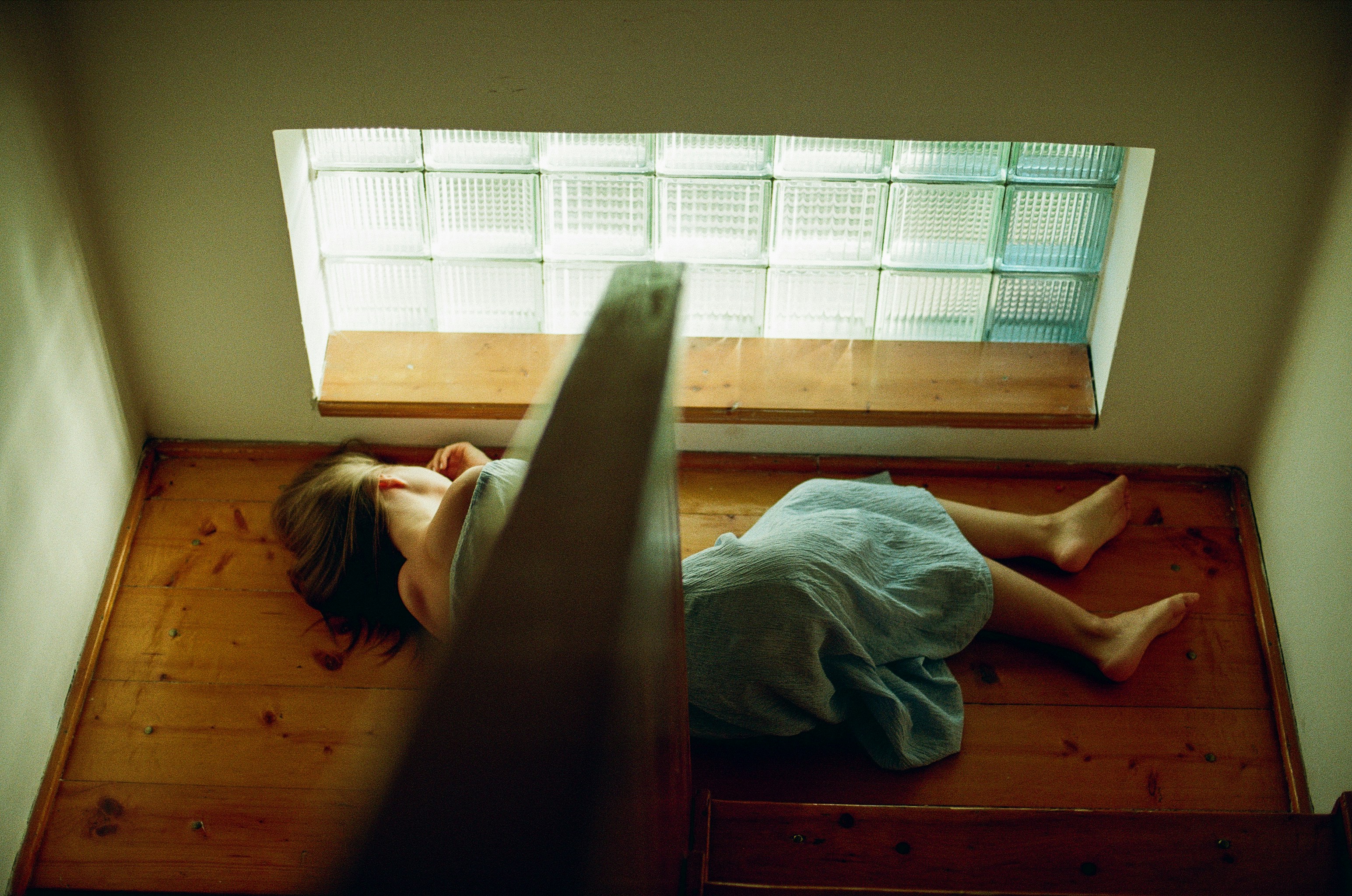 A person laying on the ground in a room photo – Free Film photography ...