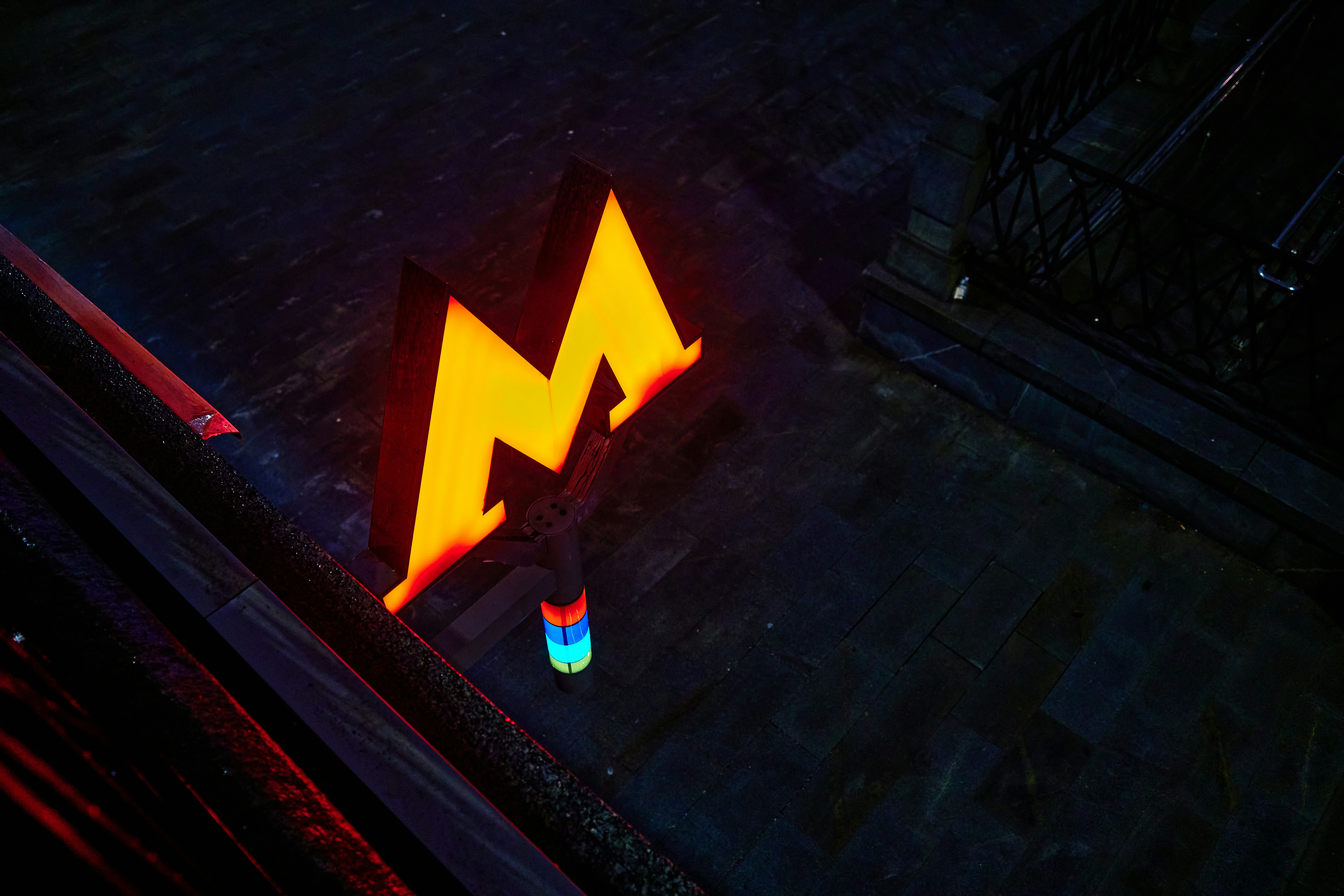 Neon M on a Rain-Damp Rooftop