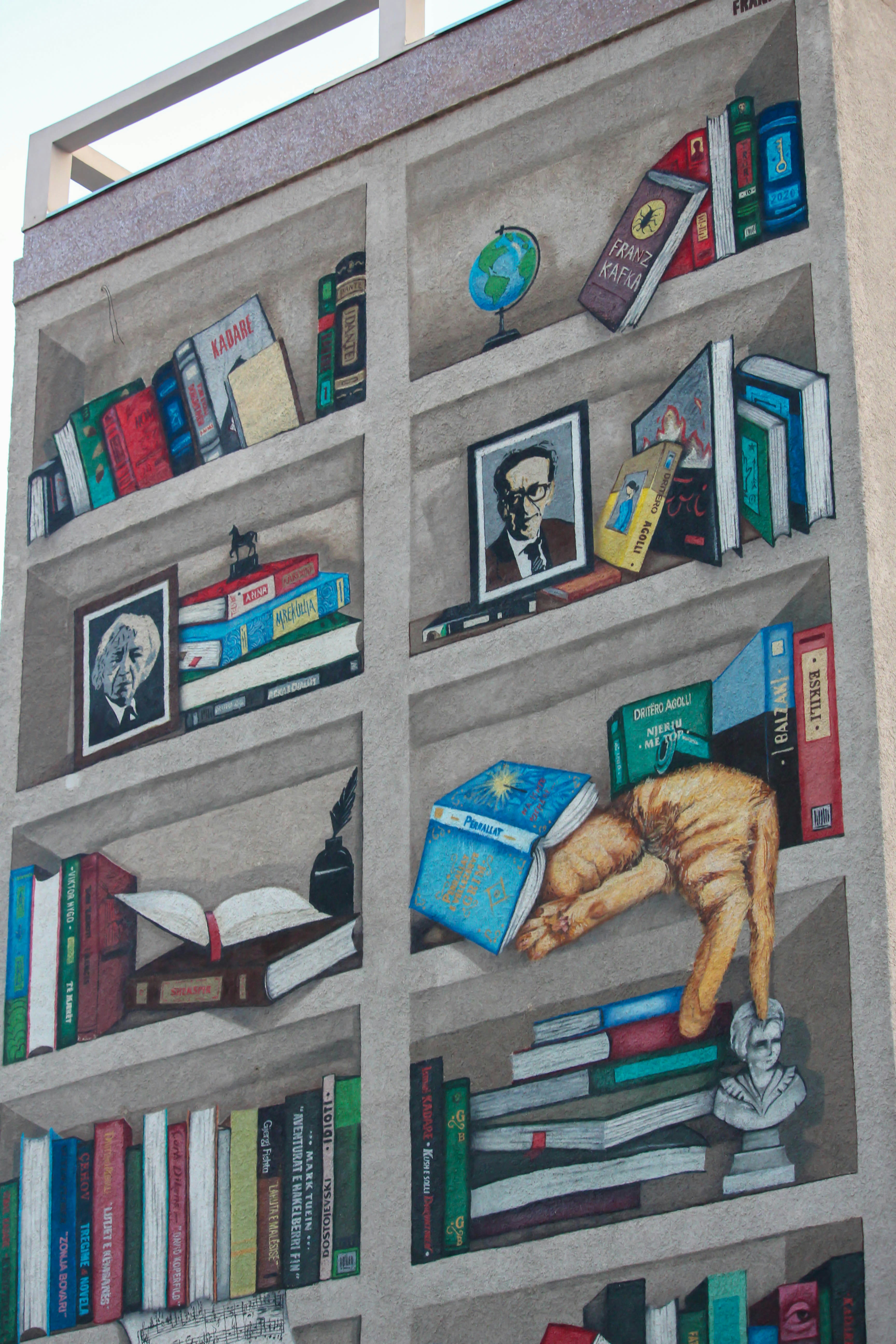 Graffitied Library Shelves: A Muralscape of Knowledge and Quirky Figures