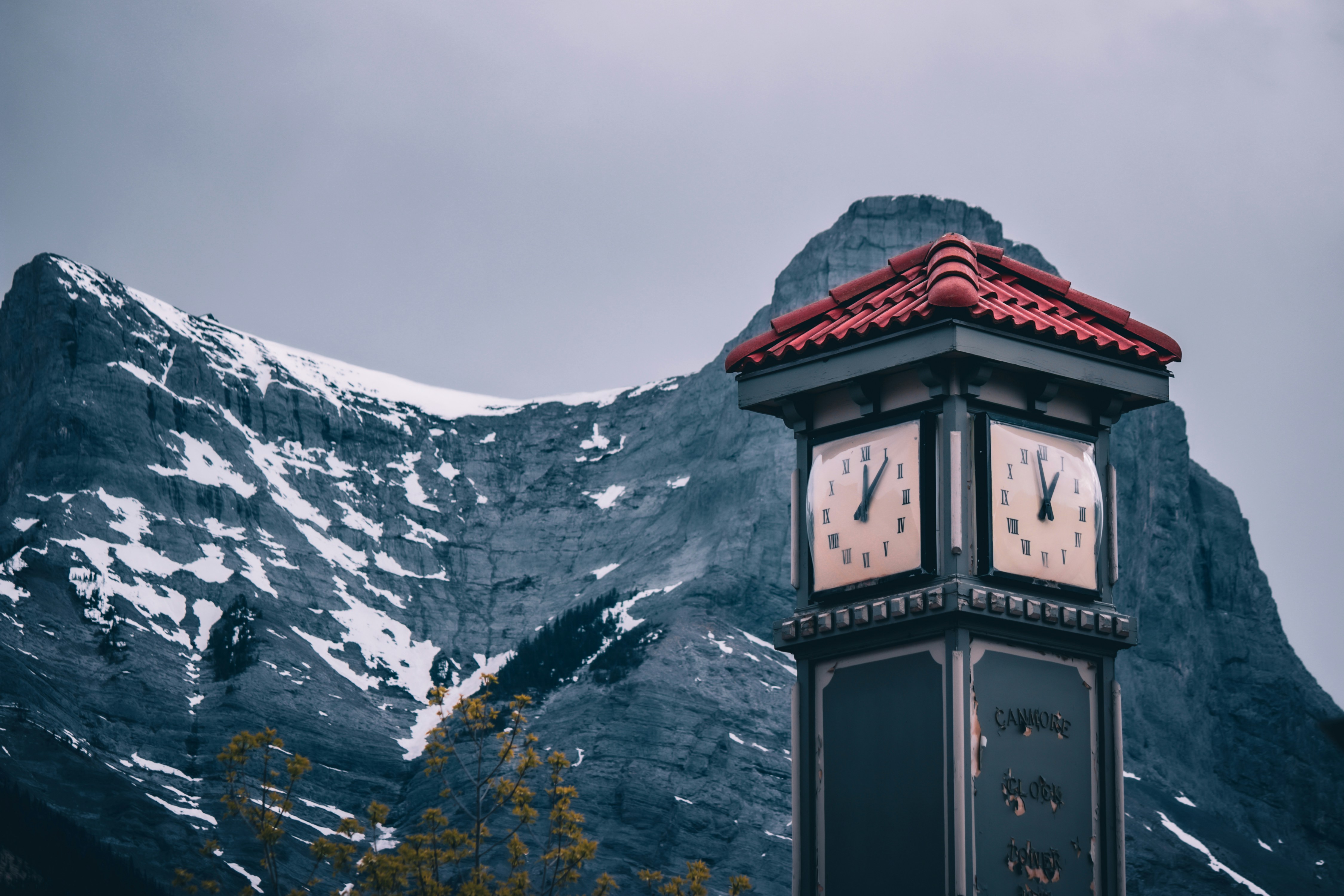 A clock tower with a mountain in the background photo – Free Mountain ...