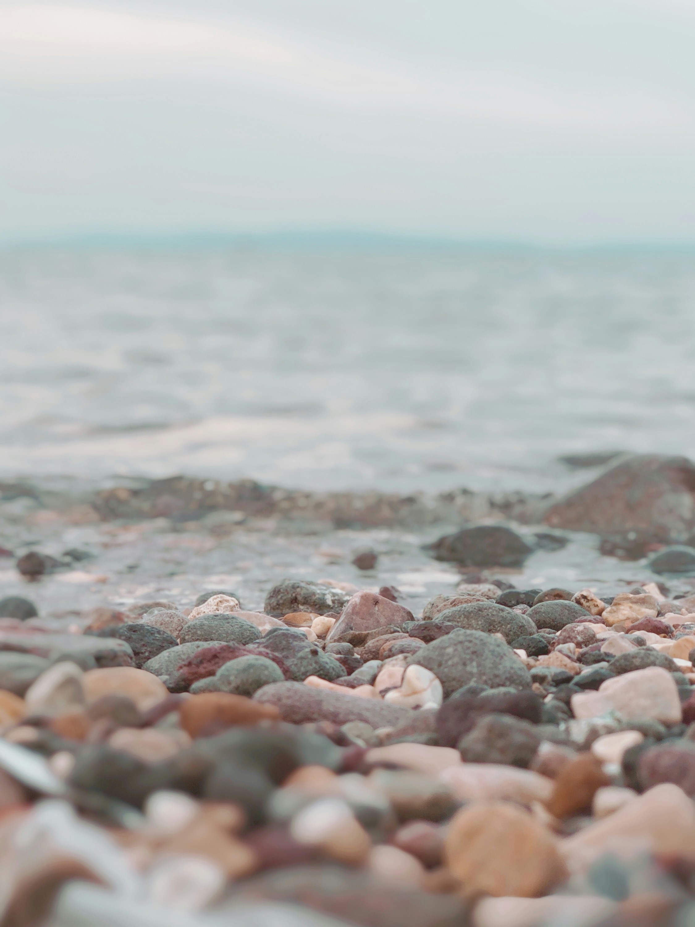 A blurry photo of rocks and water on a beach photo – Free Sea Image on ...