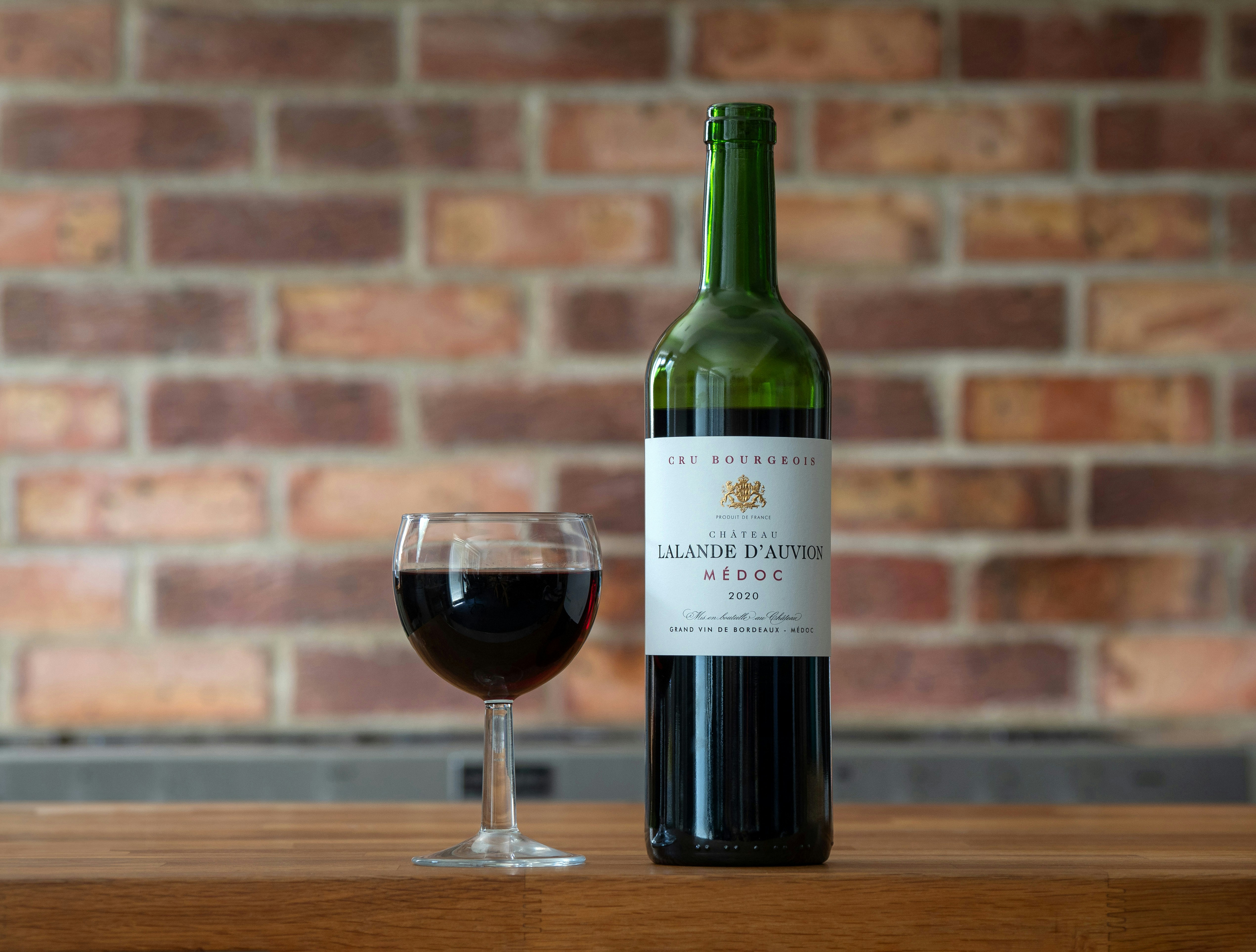 A bottle of wine and a glass of wine on a table photo – Free Alcohol ...