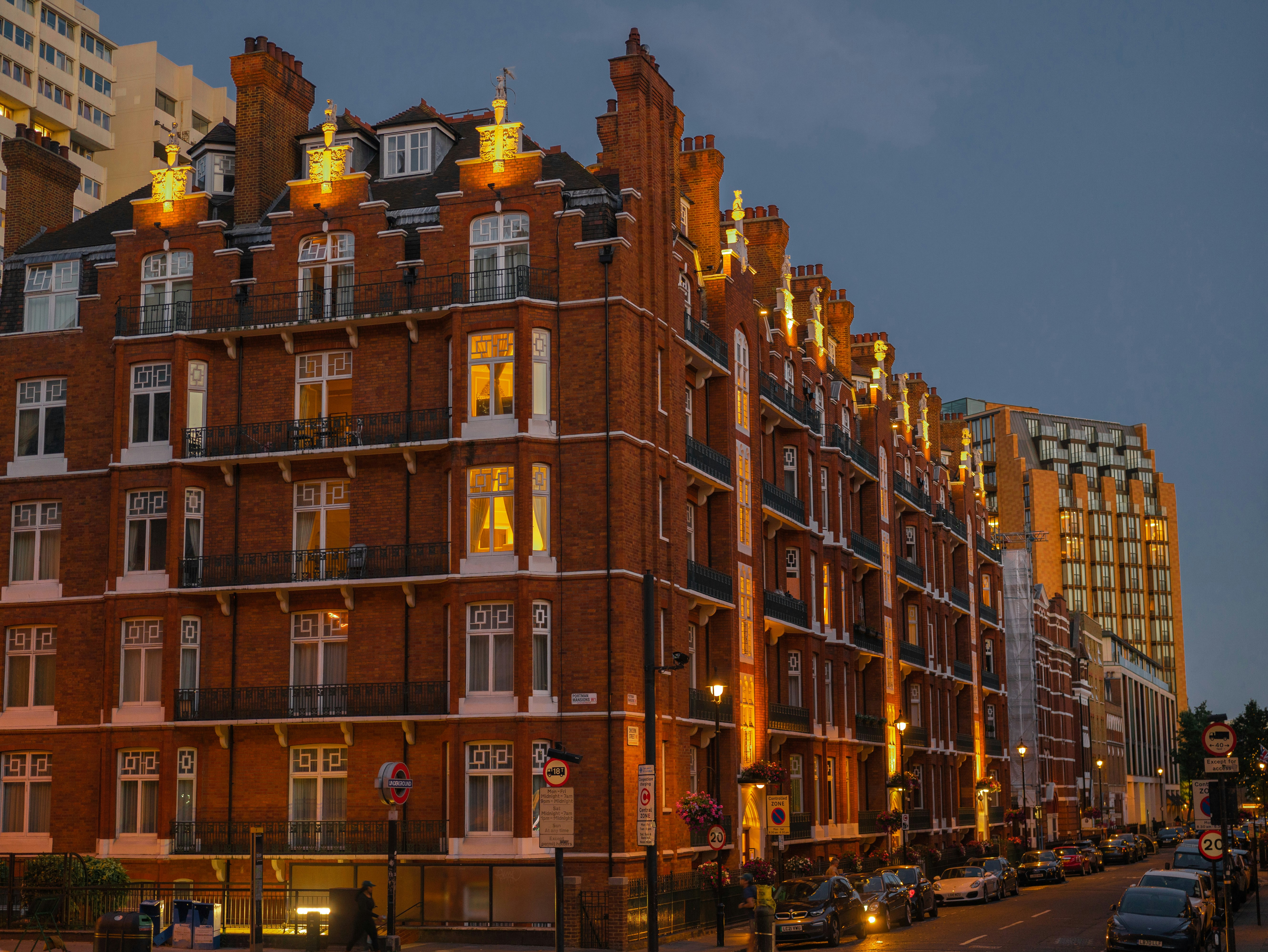 Historic brick buildings illuminated at dusk, showcasing a blend of classic and modern architectural styles.