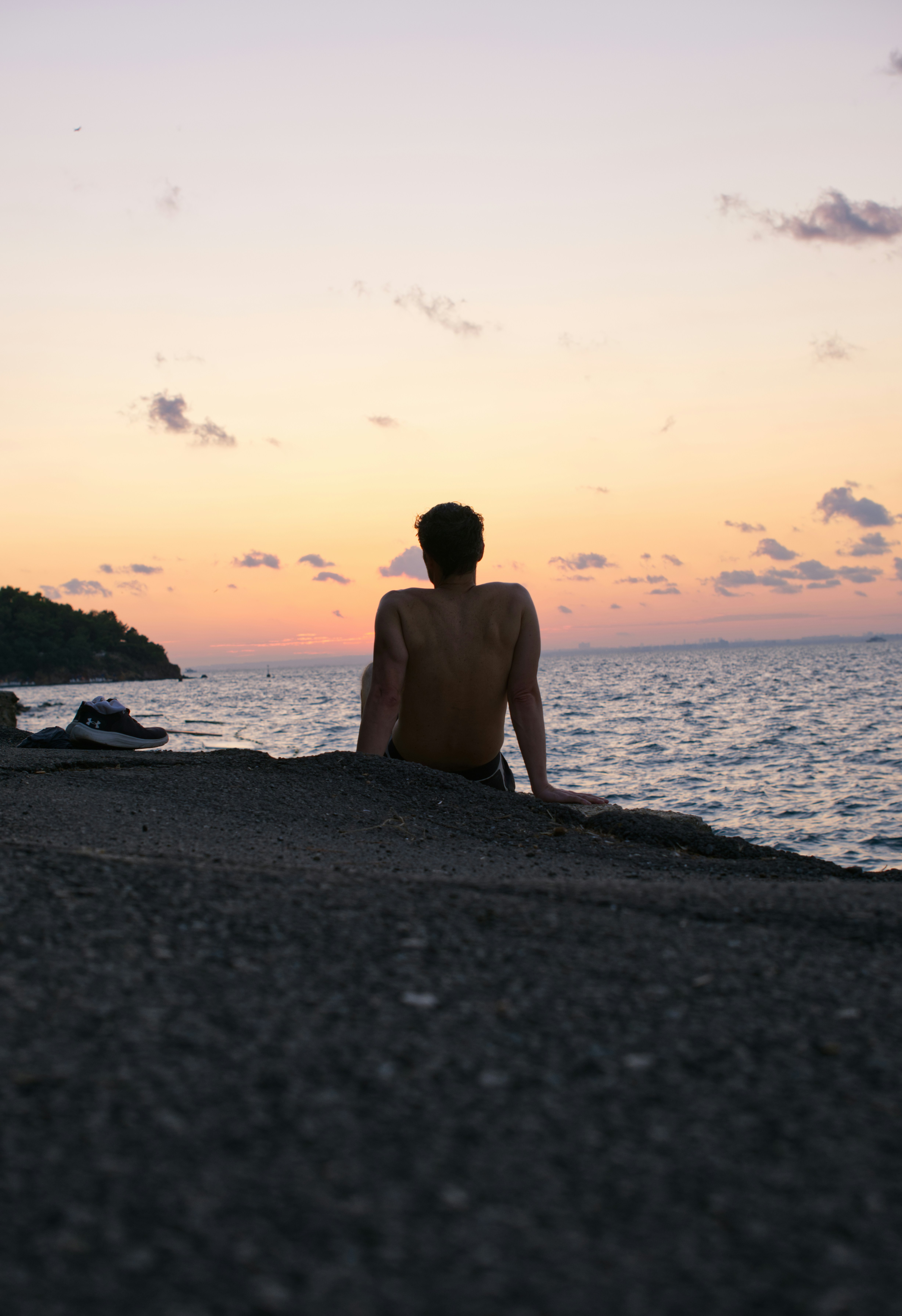 A person sitting on a beach watching the sunset photo – Free Beach ...