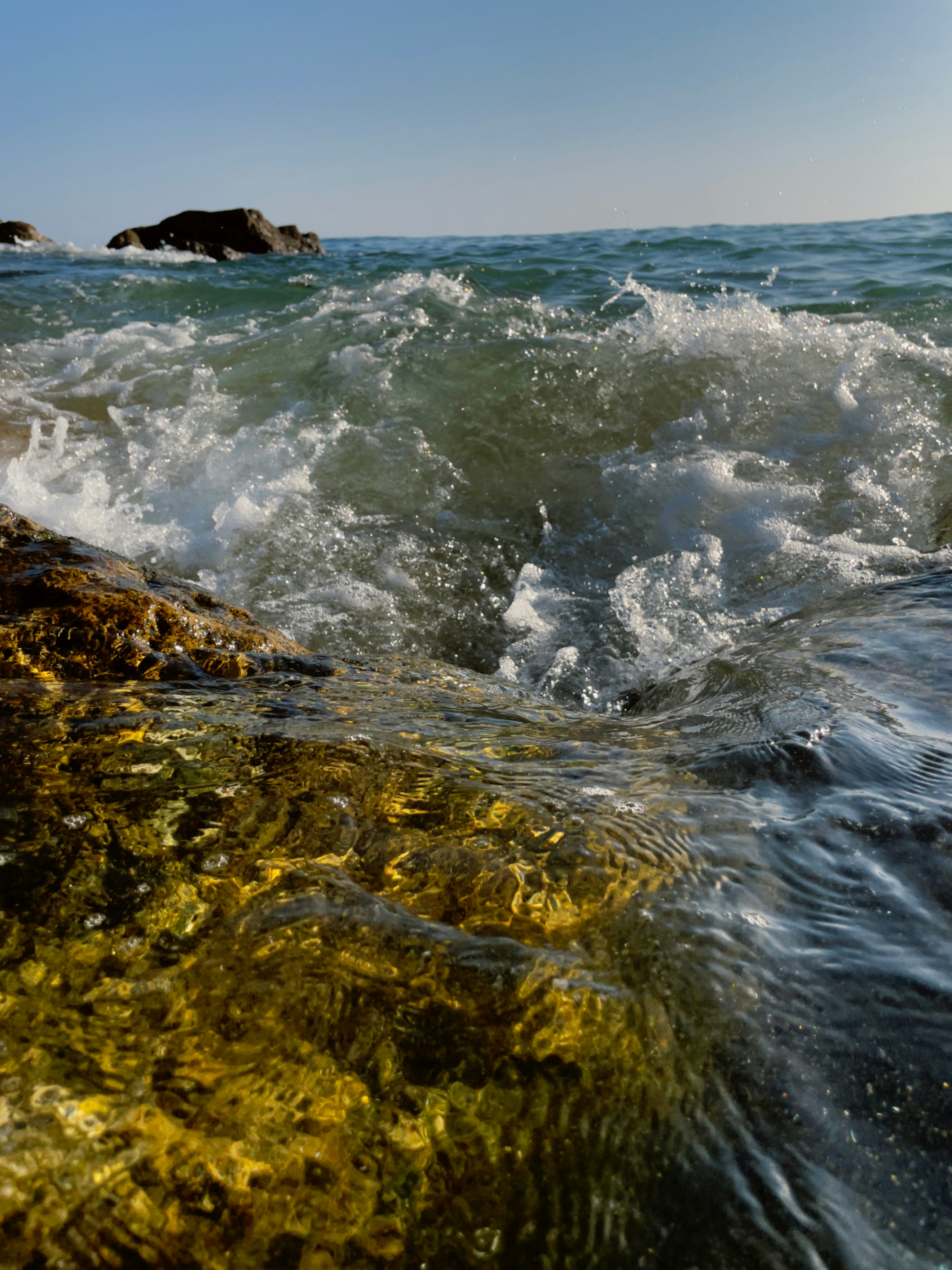 Granite at the Edge: Sunlit Shallows and Rolling Surf