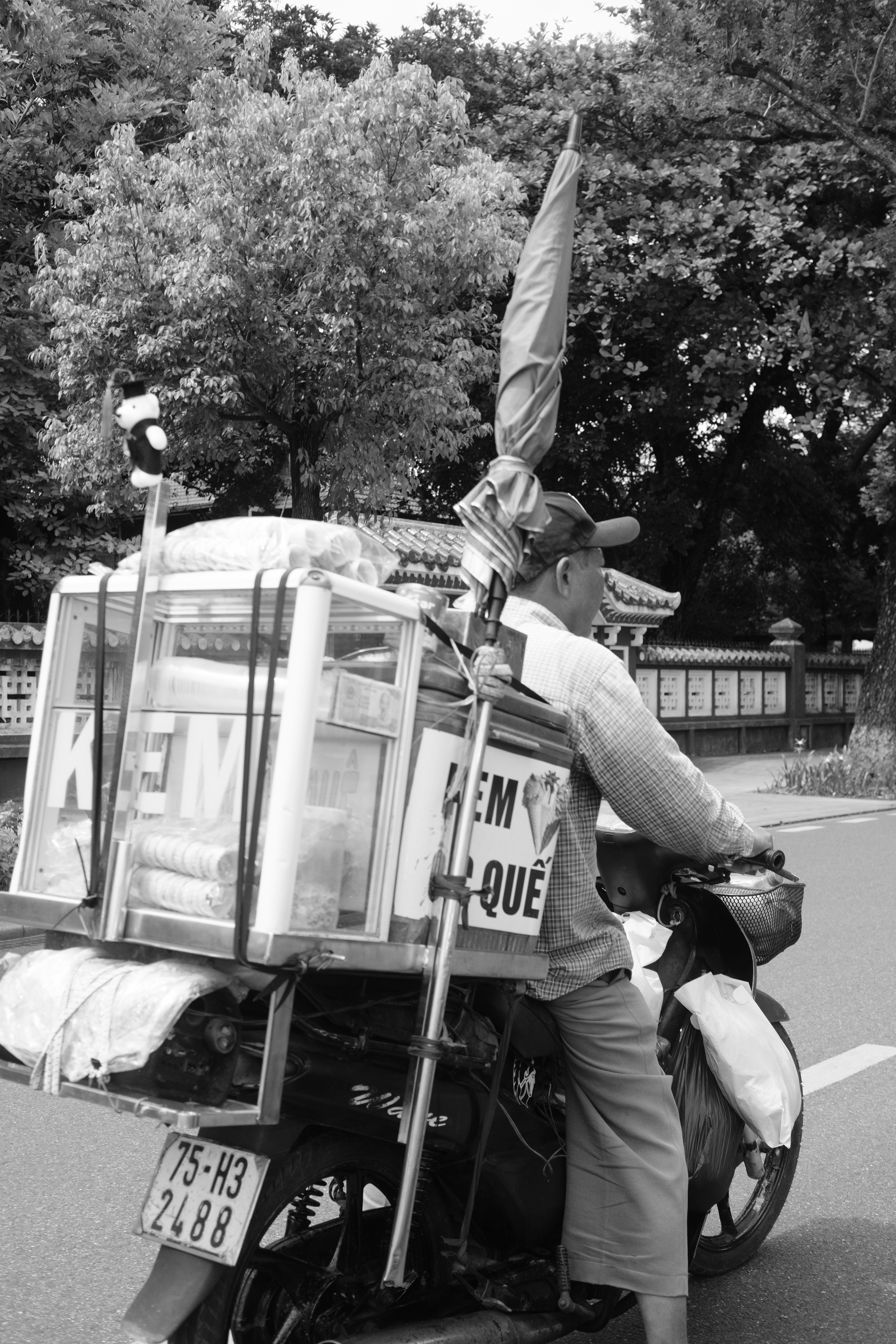 Umbrella Carrier on a City Street: A Black-and-White Snapshot