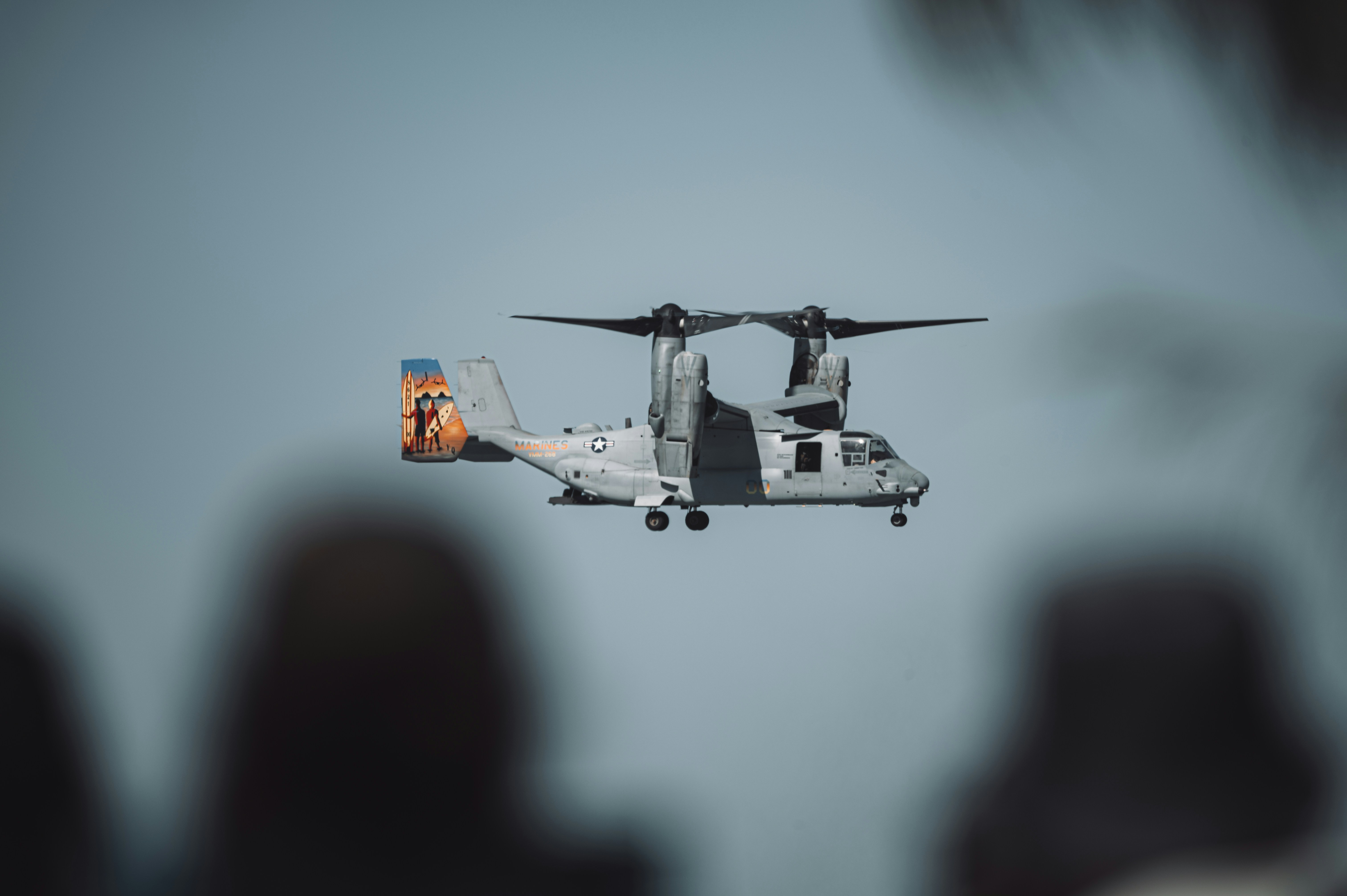 Twin-rotor coalescence: a helicopter silhouette hovering above a blurred crowd