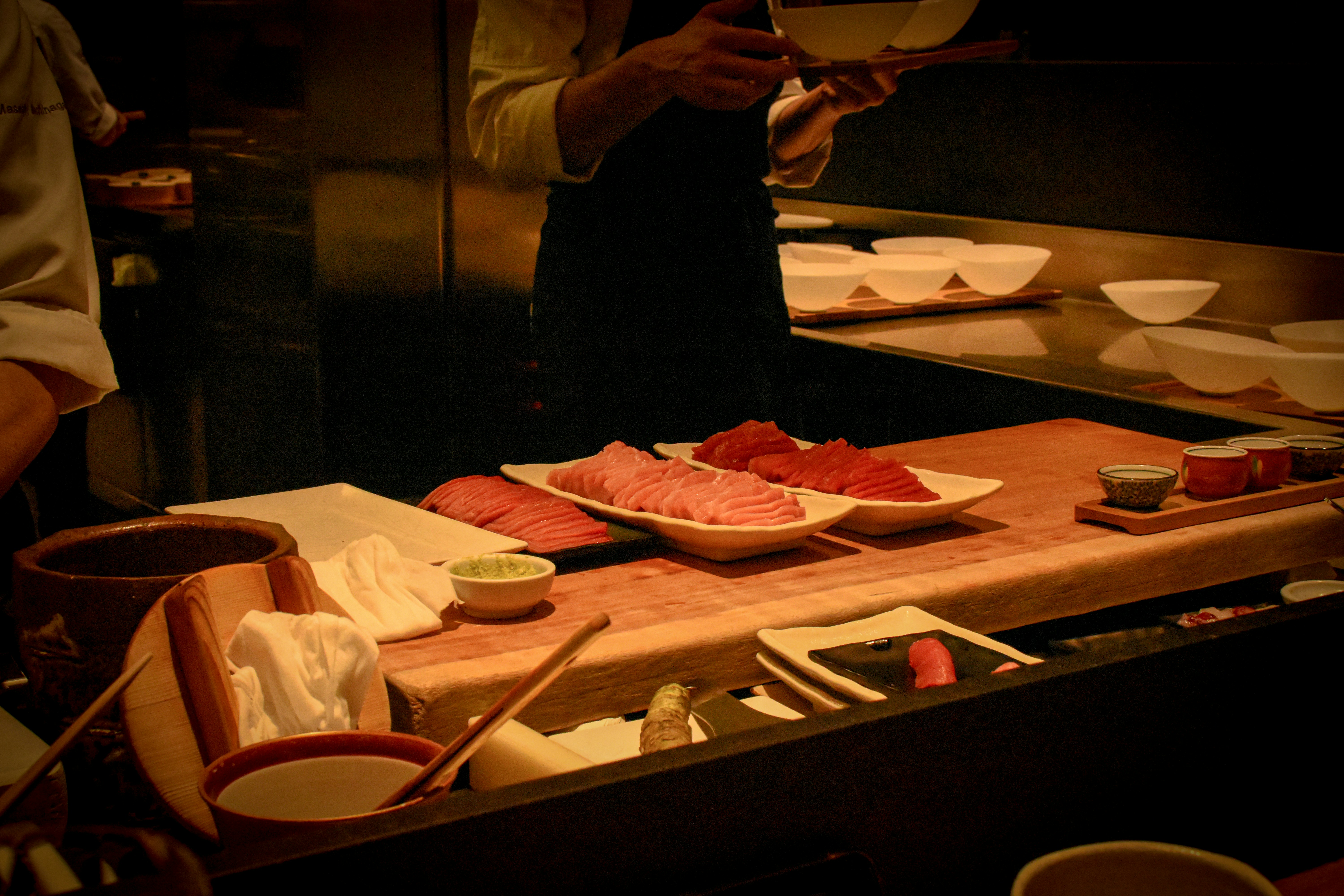 A man standing in front of a counter filled with plates of food photo ...