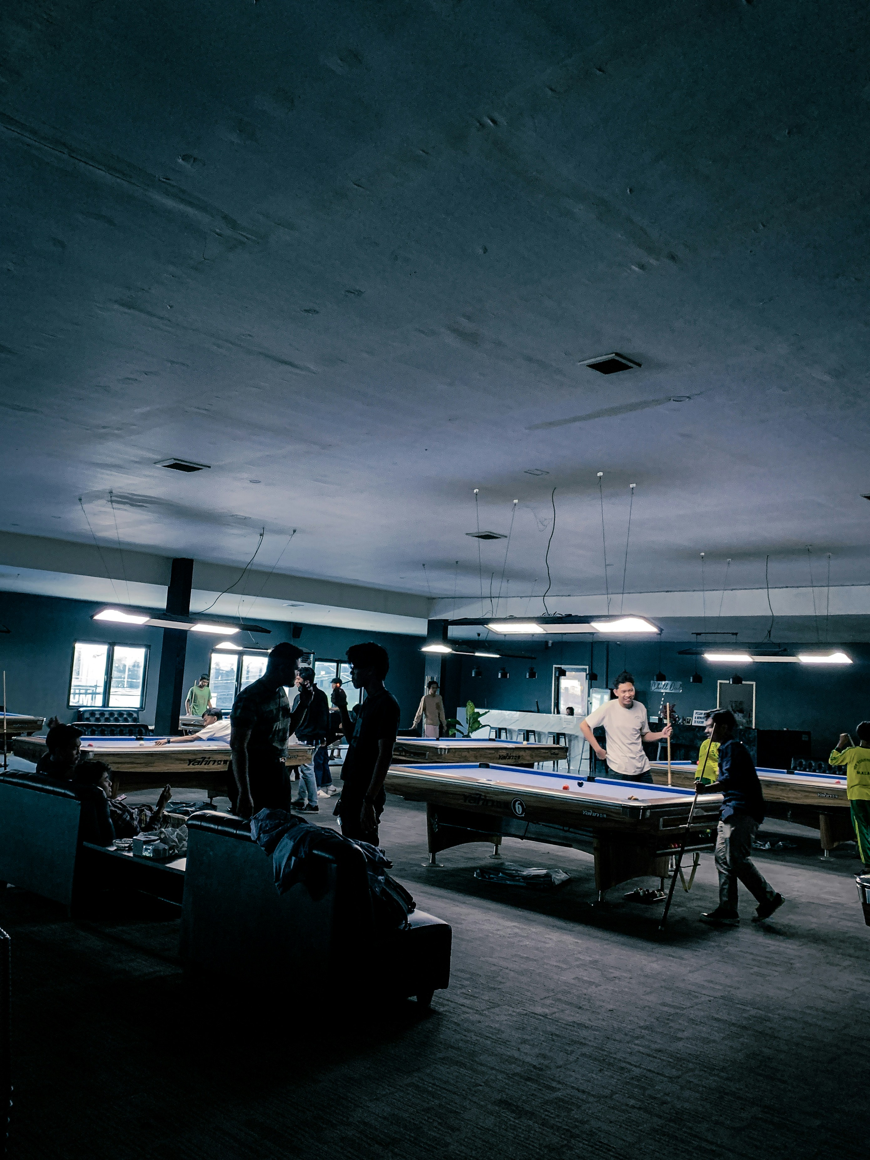 A group of people standing around a pool table photo – Free People ...